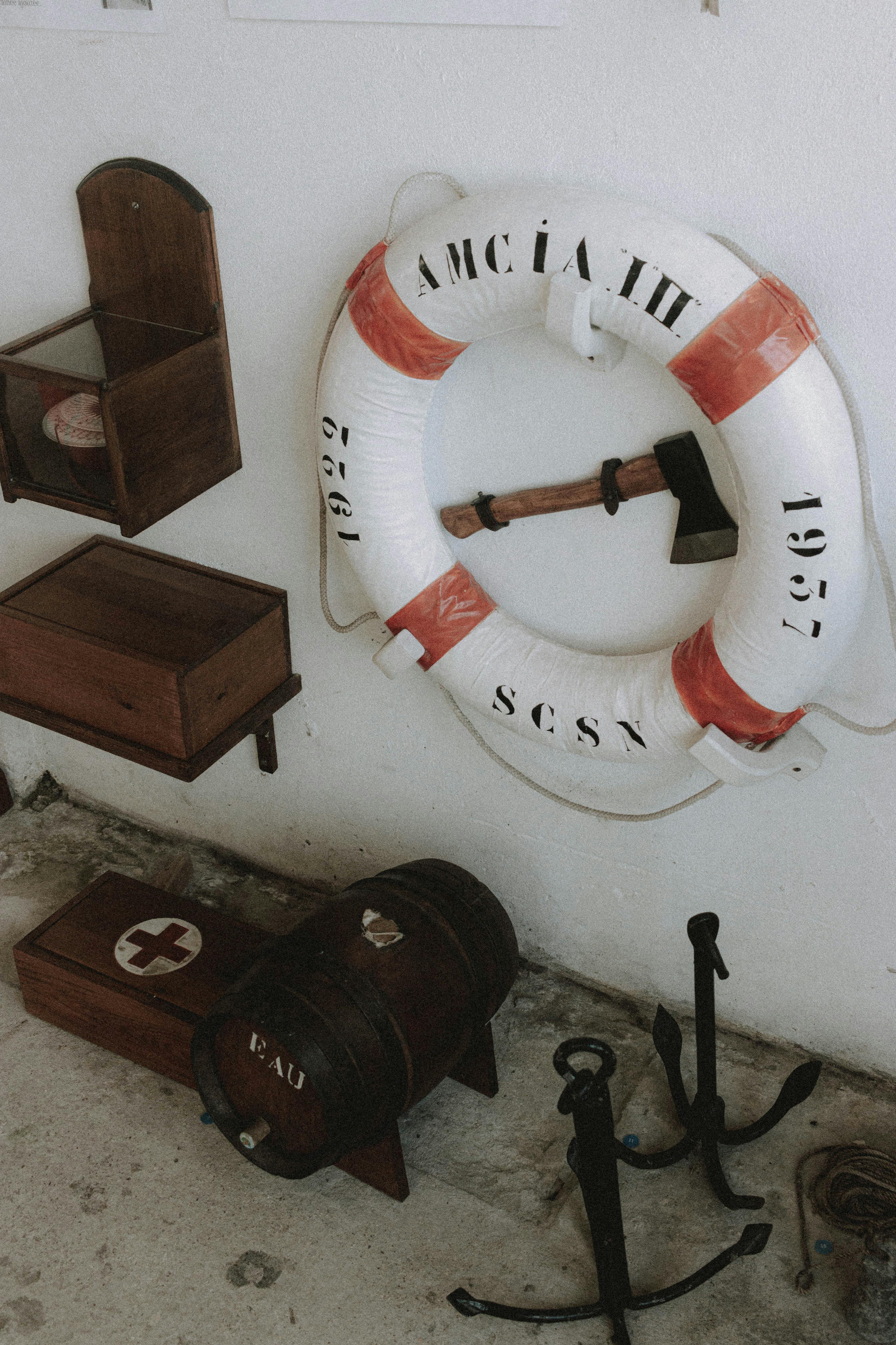 White lifebuoy hanging on wall near wooden shelves · Free Stock Photo