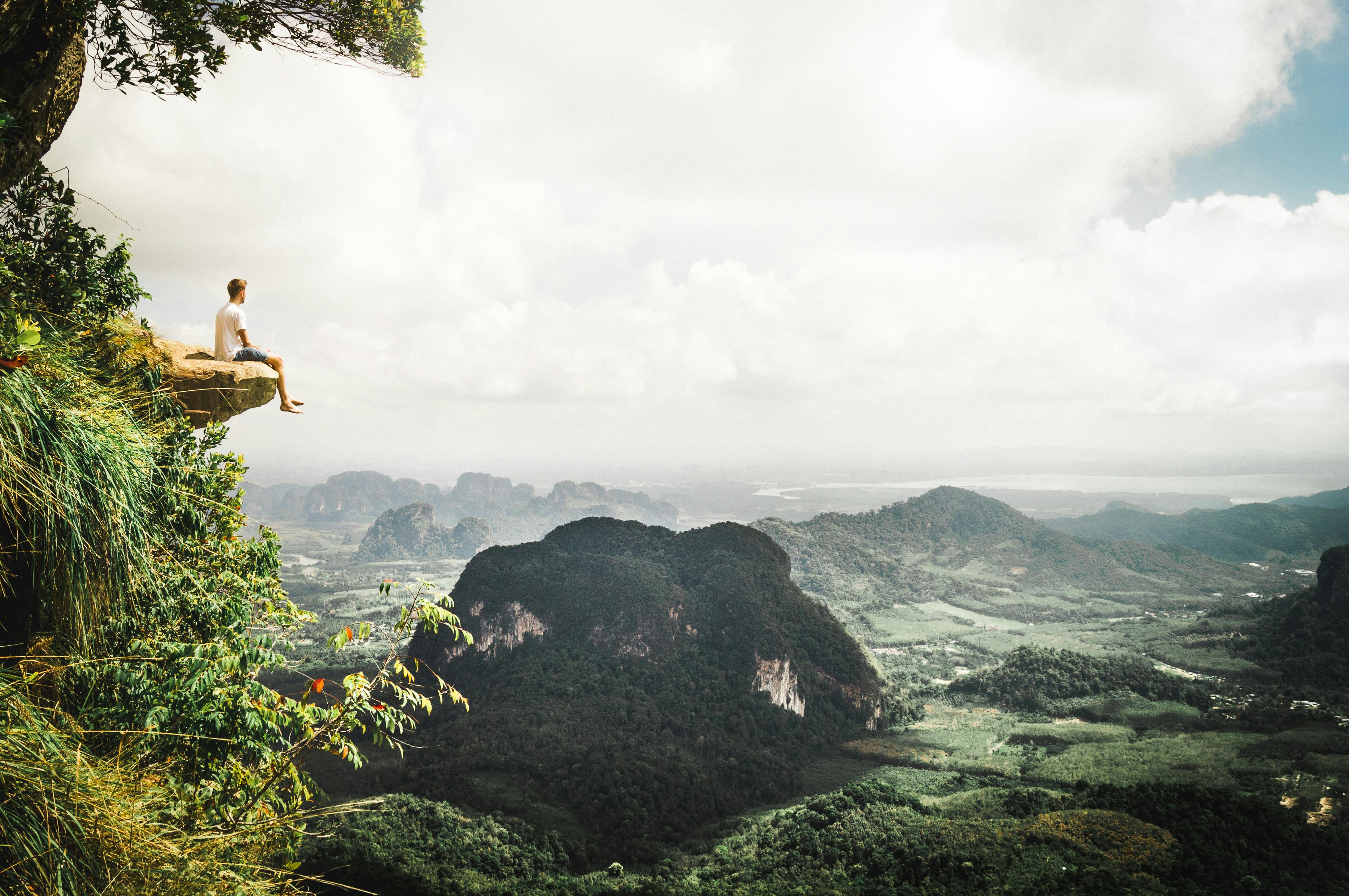 A Man Sitting on Cliff Under a Tree Looking at the Beautiful Nature ...