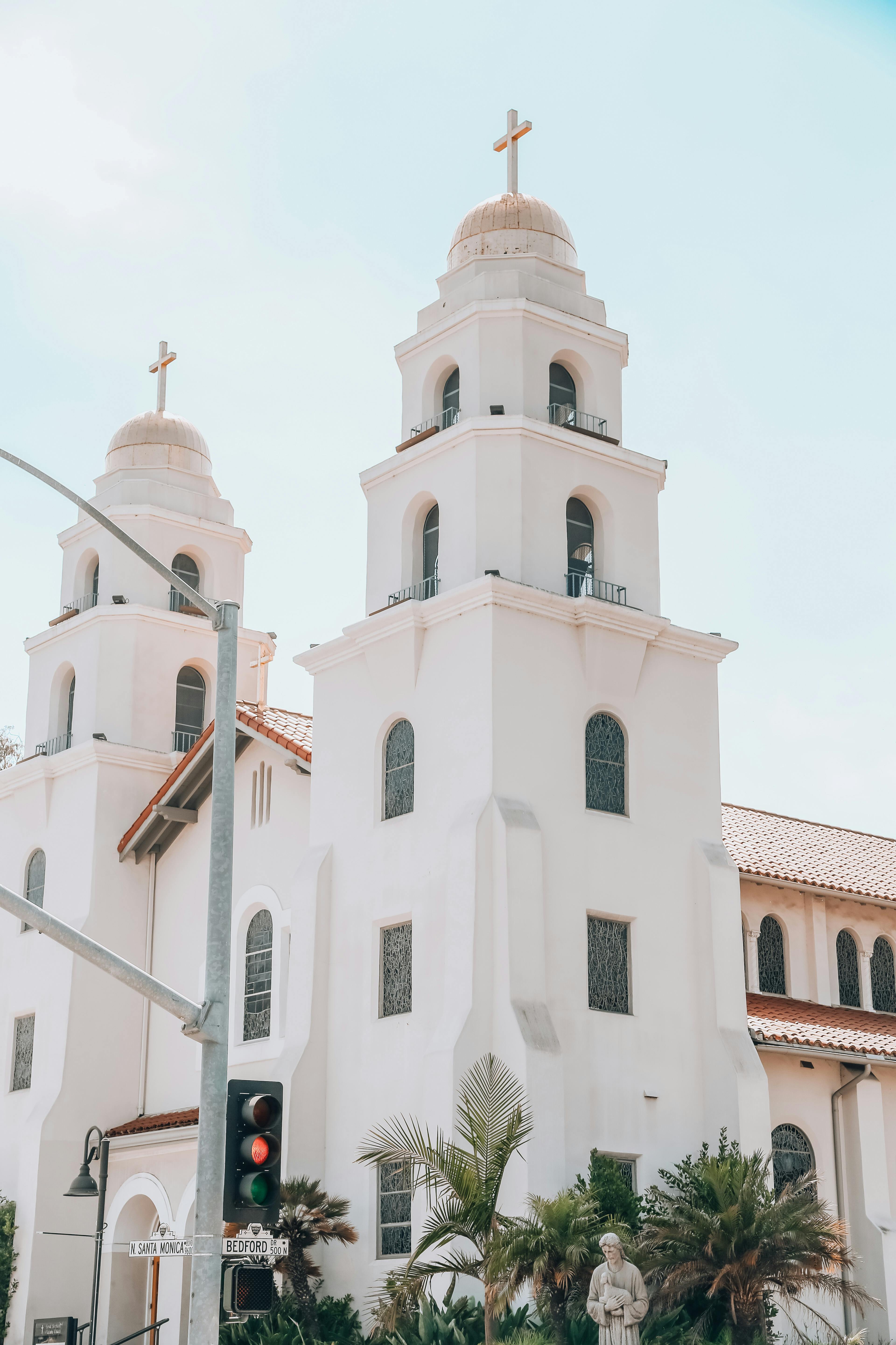 Old stone basilica facade near greenery trees in town · Free Stock Photo