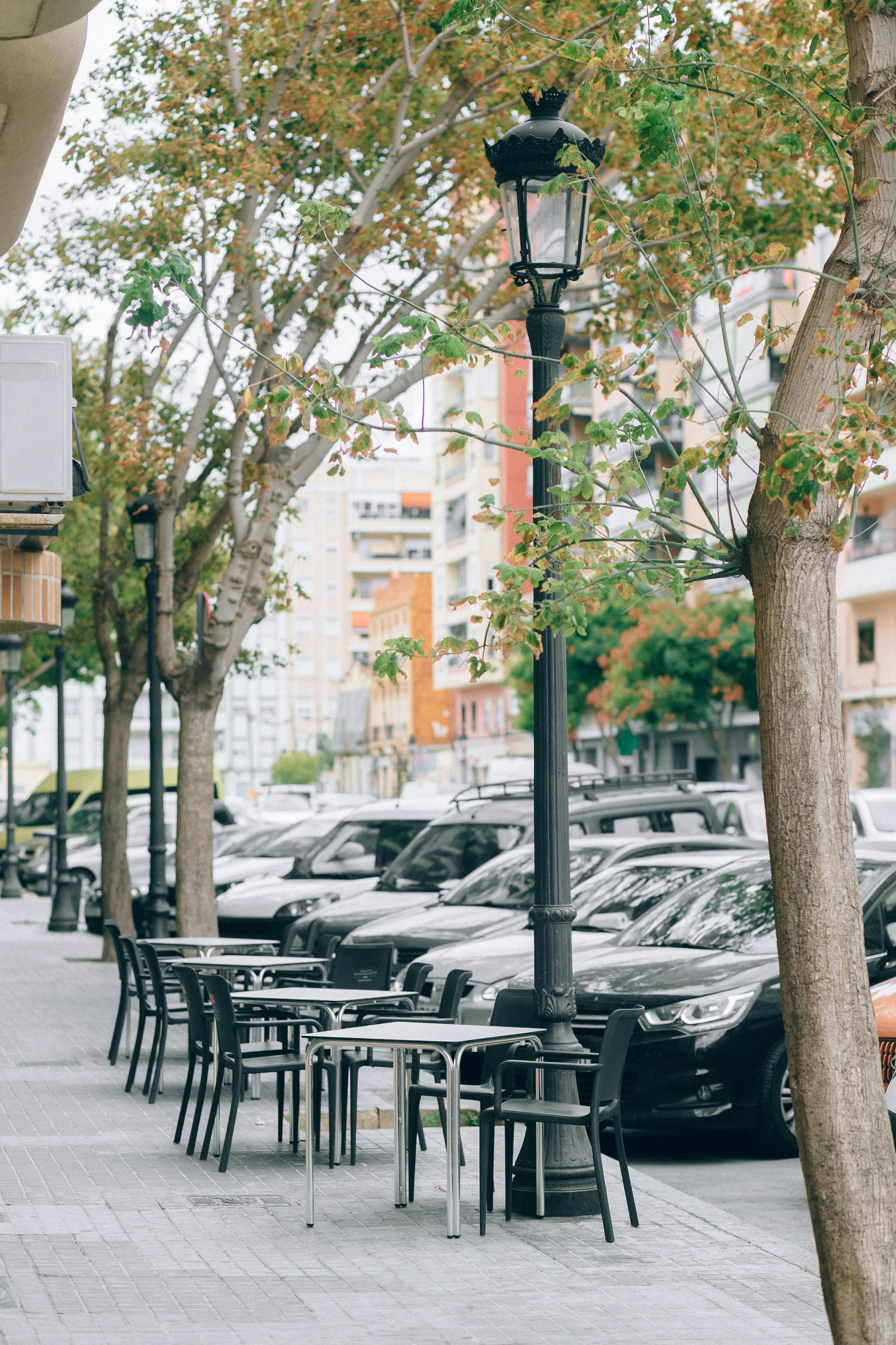 Tables and Chair on the Sidewalk Near Parked Cars · Free Stock Photo