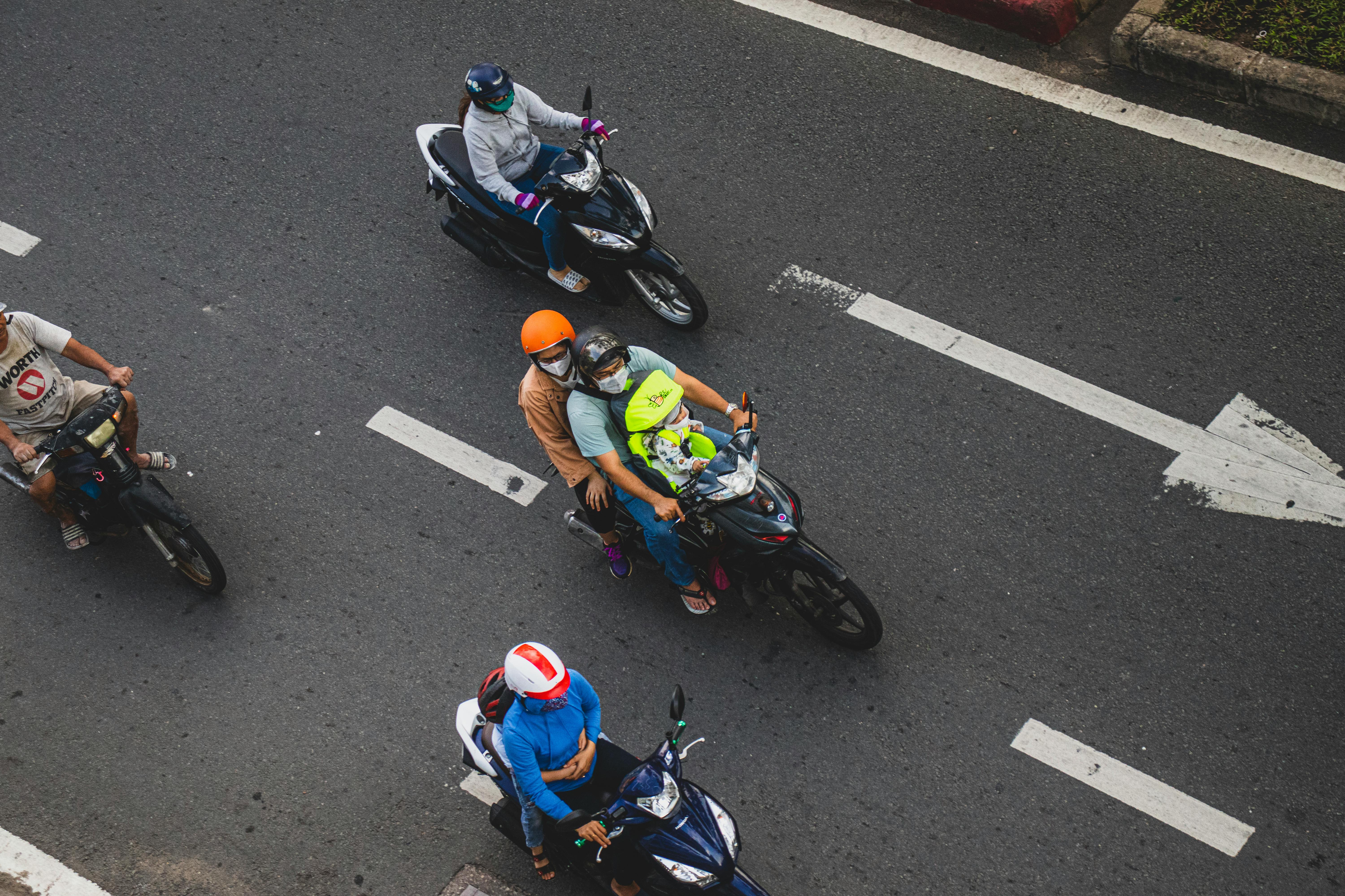 Person Riding on Yellow Motor Scooter on Road · Free Stock Photo