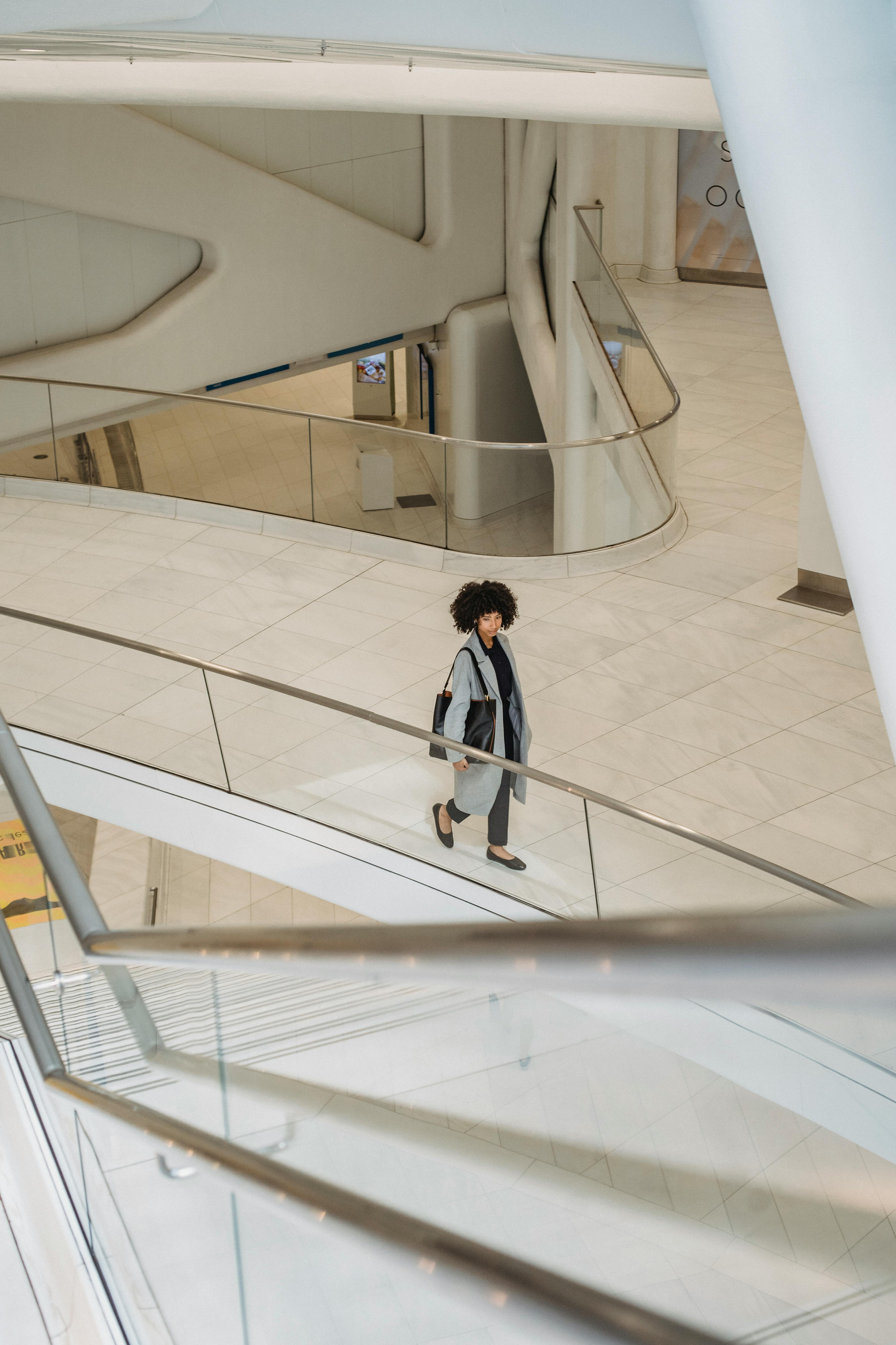 Ethnic woman walking in modern building · Free Stock Photo