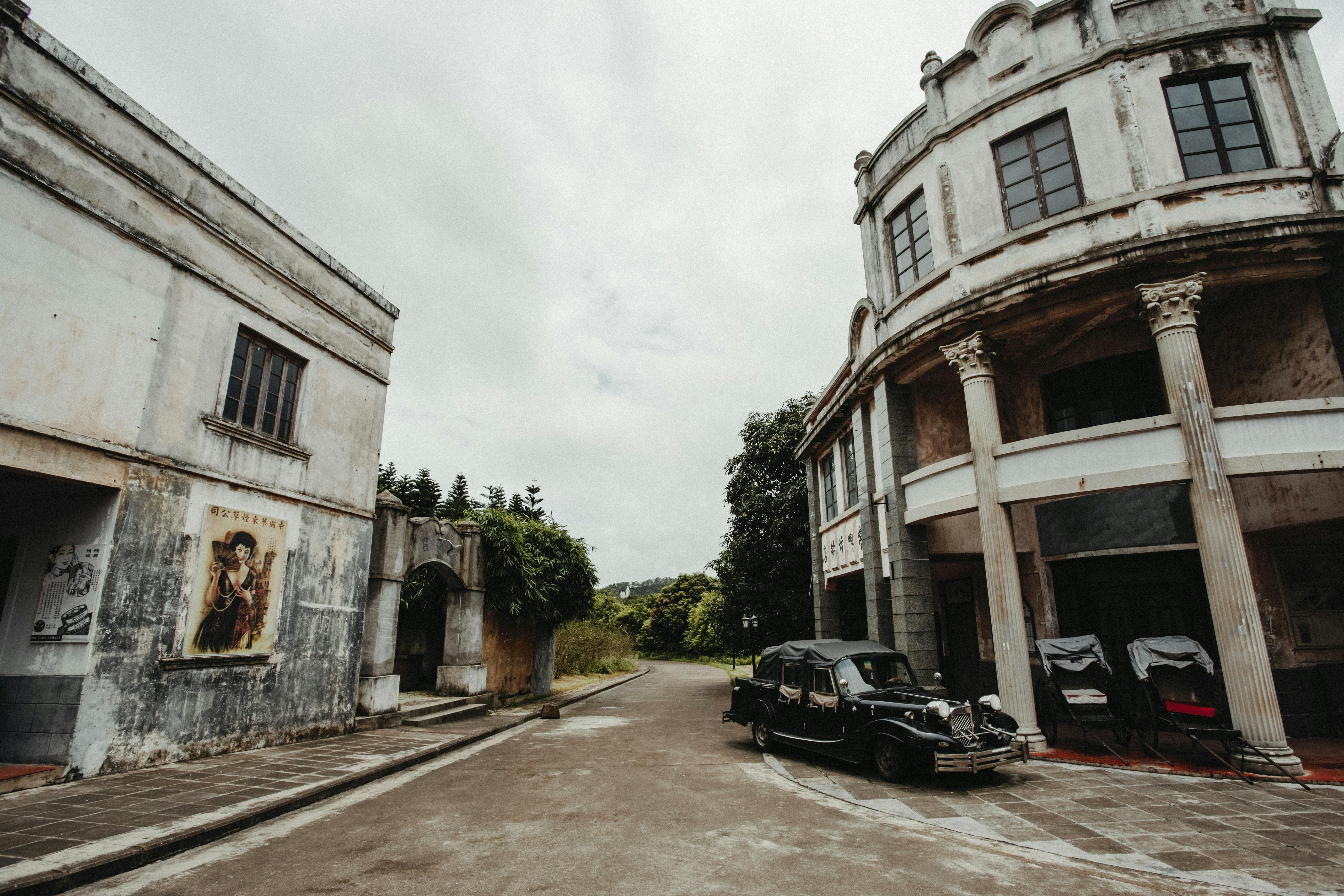 Old building facade near retro car on road · Free Stock Photo