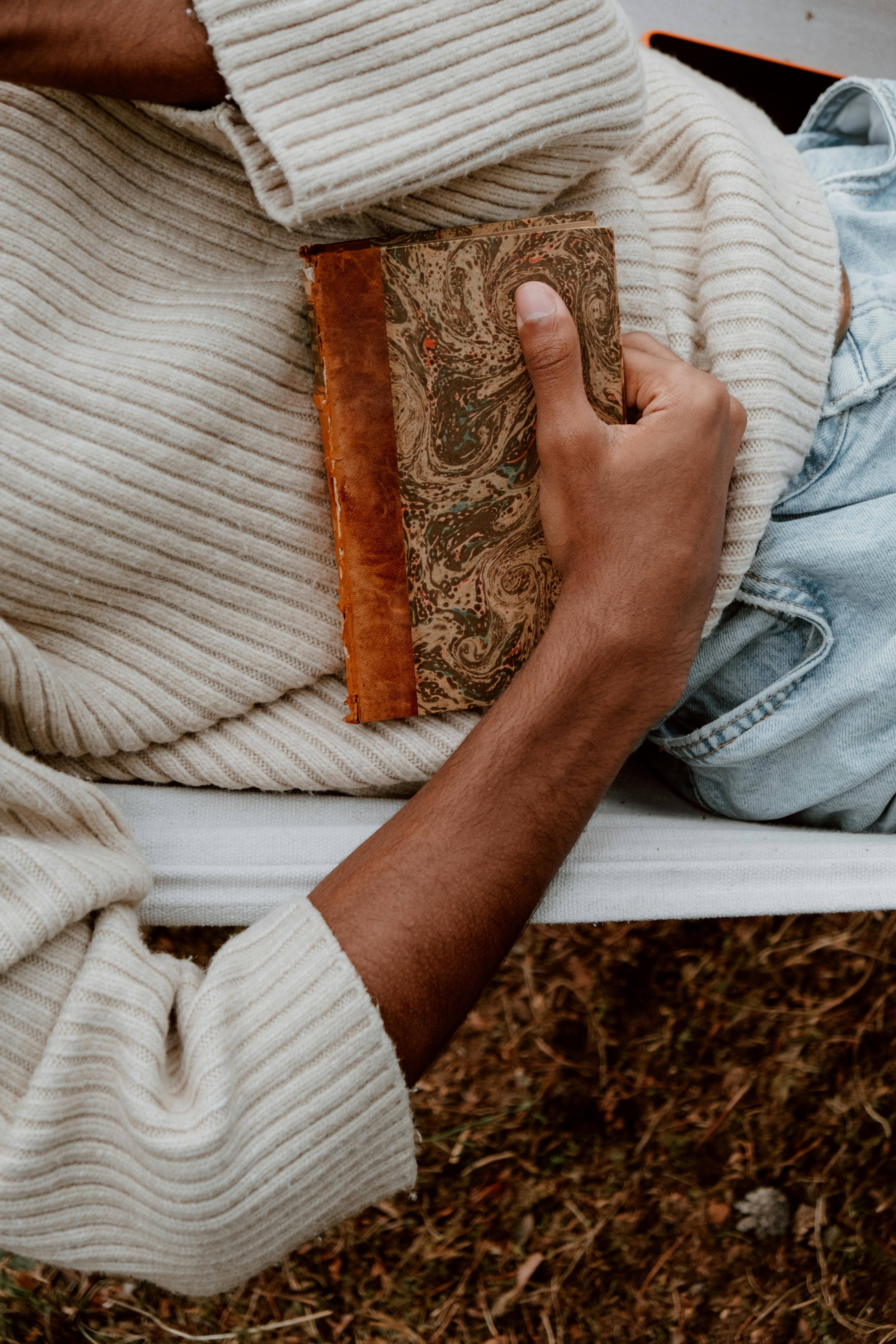 Photo of a Person's Hand Holding a Notebook · Free Stock Photo