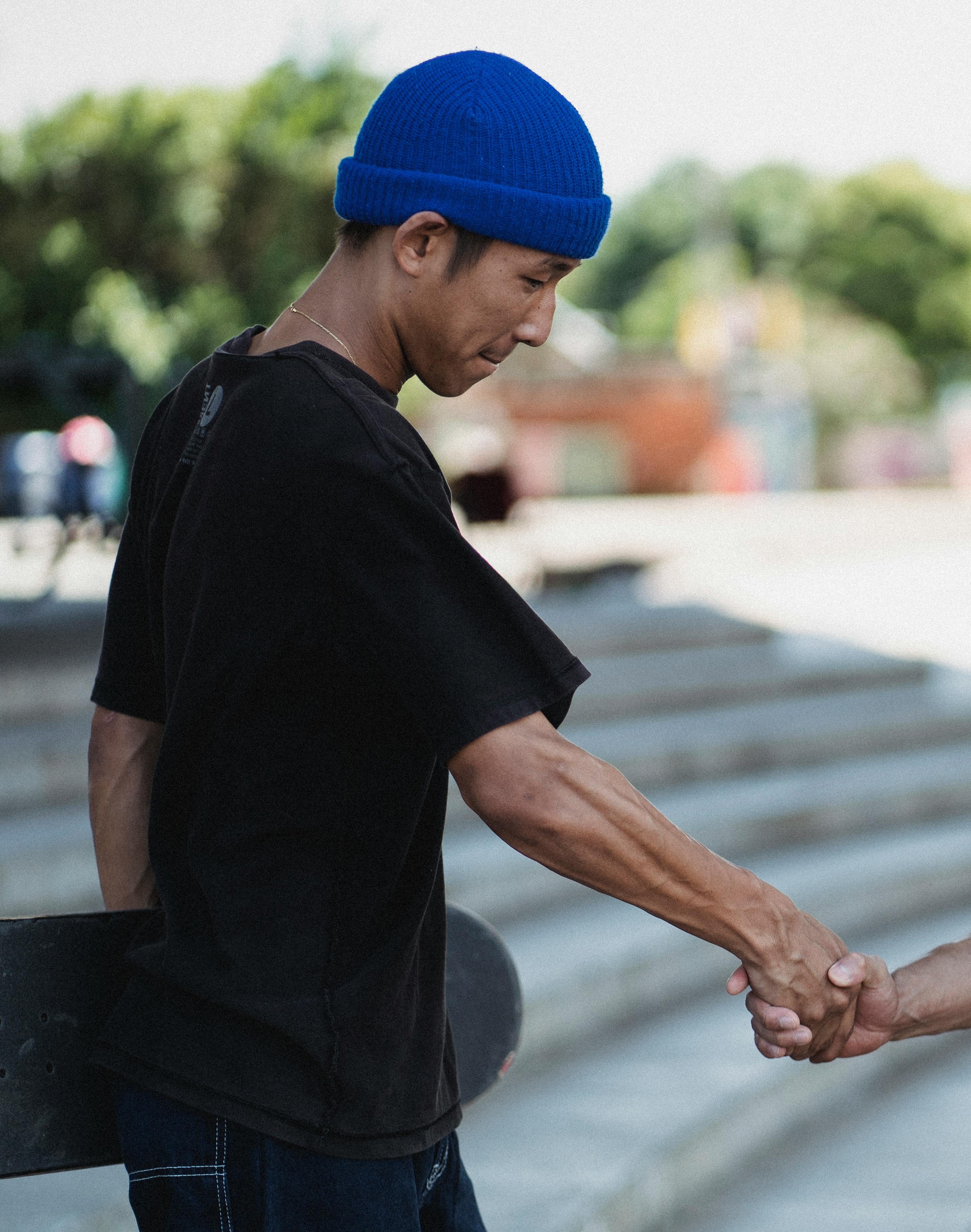 Man with skateboard shake hands in park · Free Stock Photo