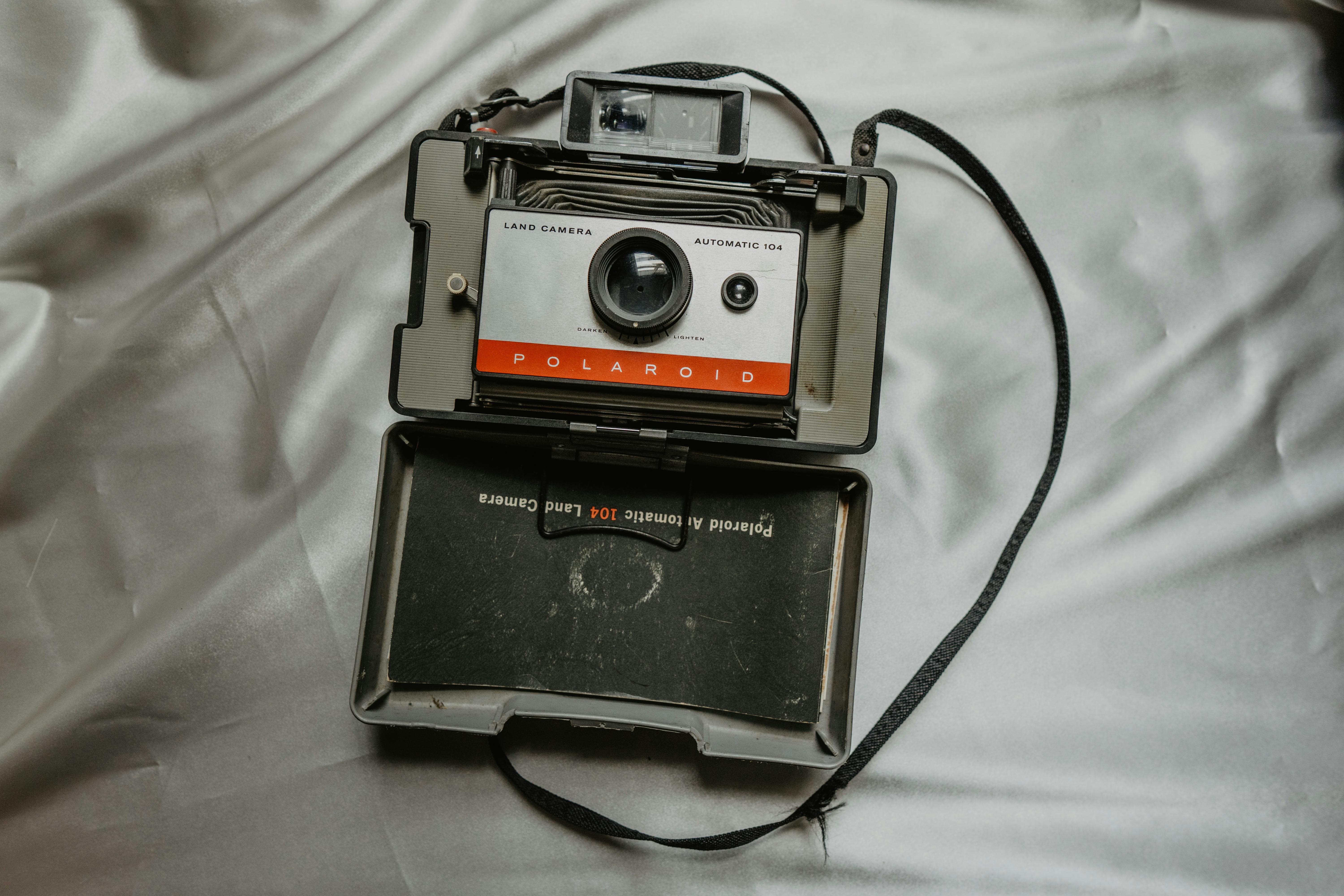 Close-Up Shot of a Polaroid Camera on Gray Textile · Free Stock Photo