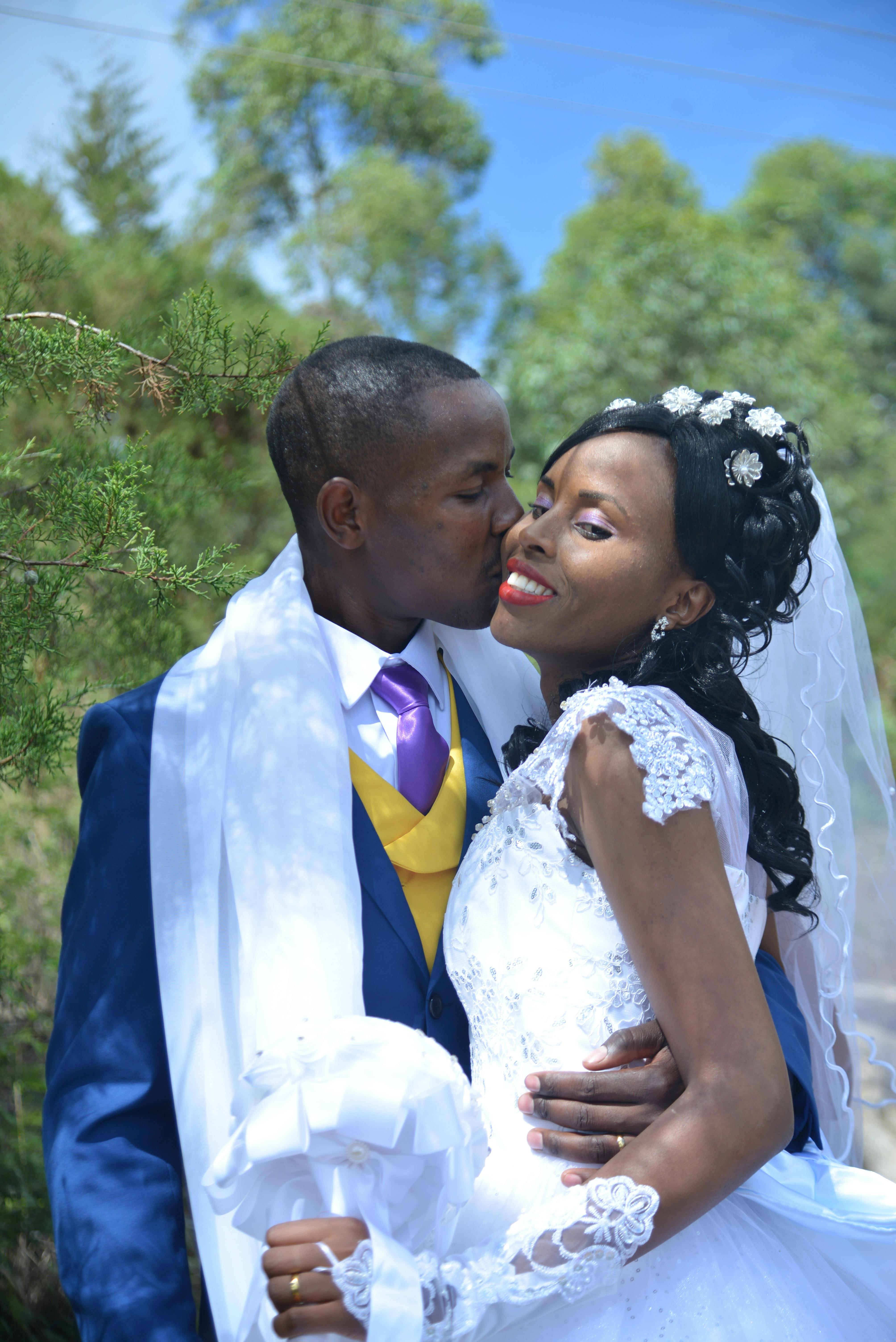 Man in Suit Kissing Woman in Wedding Dress · Free Stock Photo