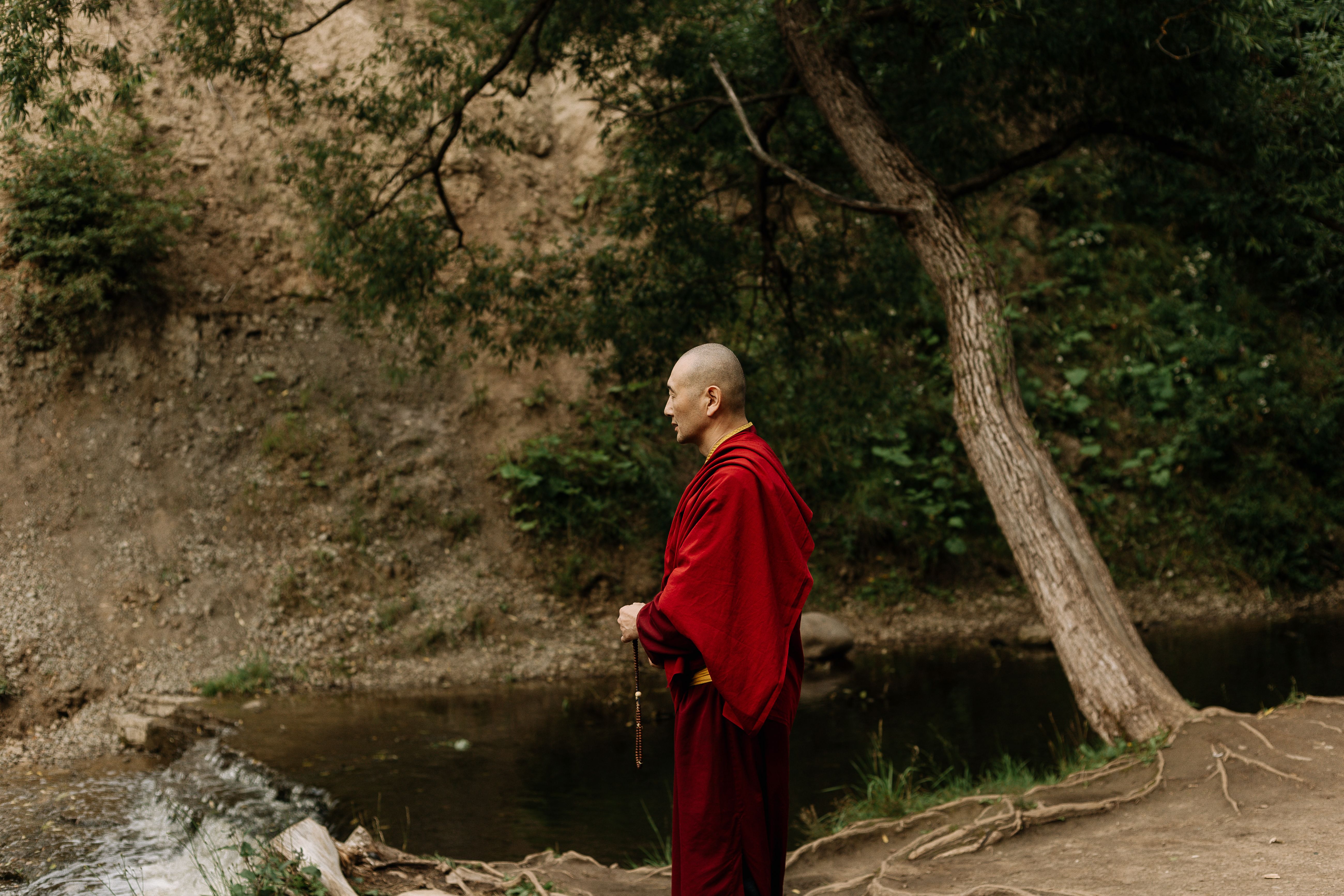 Back View of a Monk Standing Near the River · Free Stock Photo