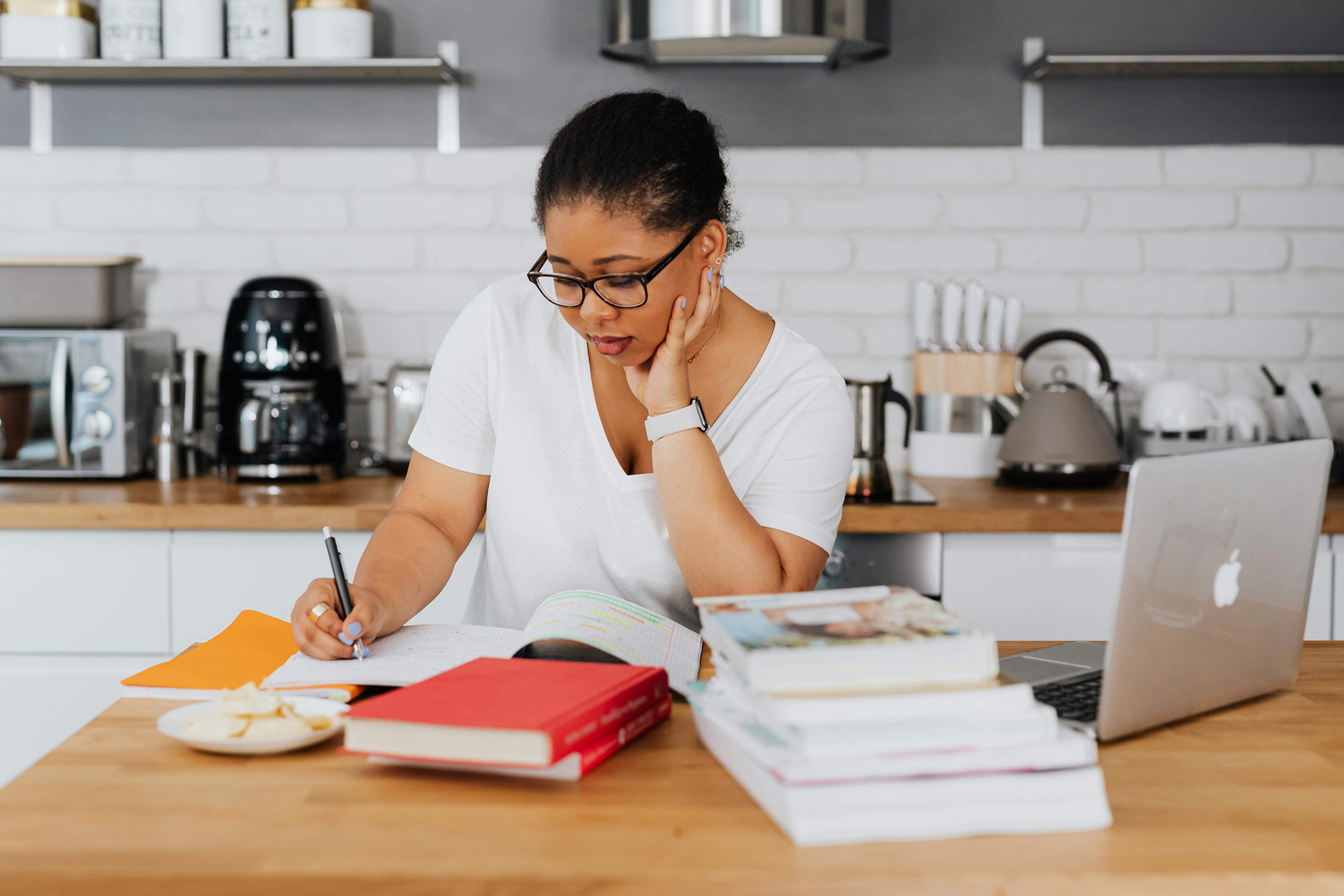 Woman Studying in a Kitchen · Free Stock Photo