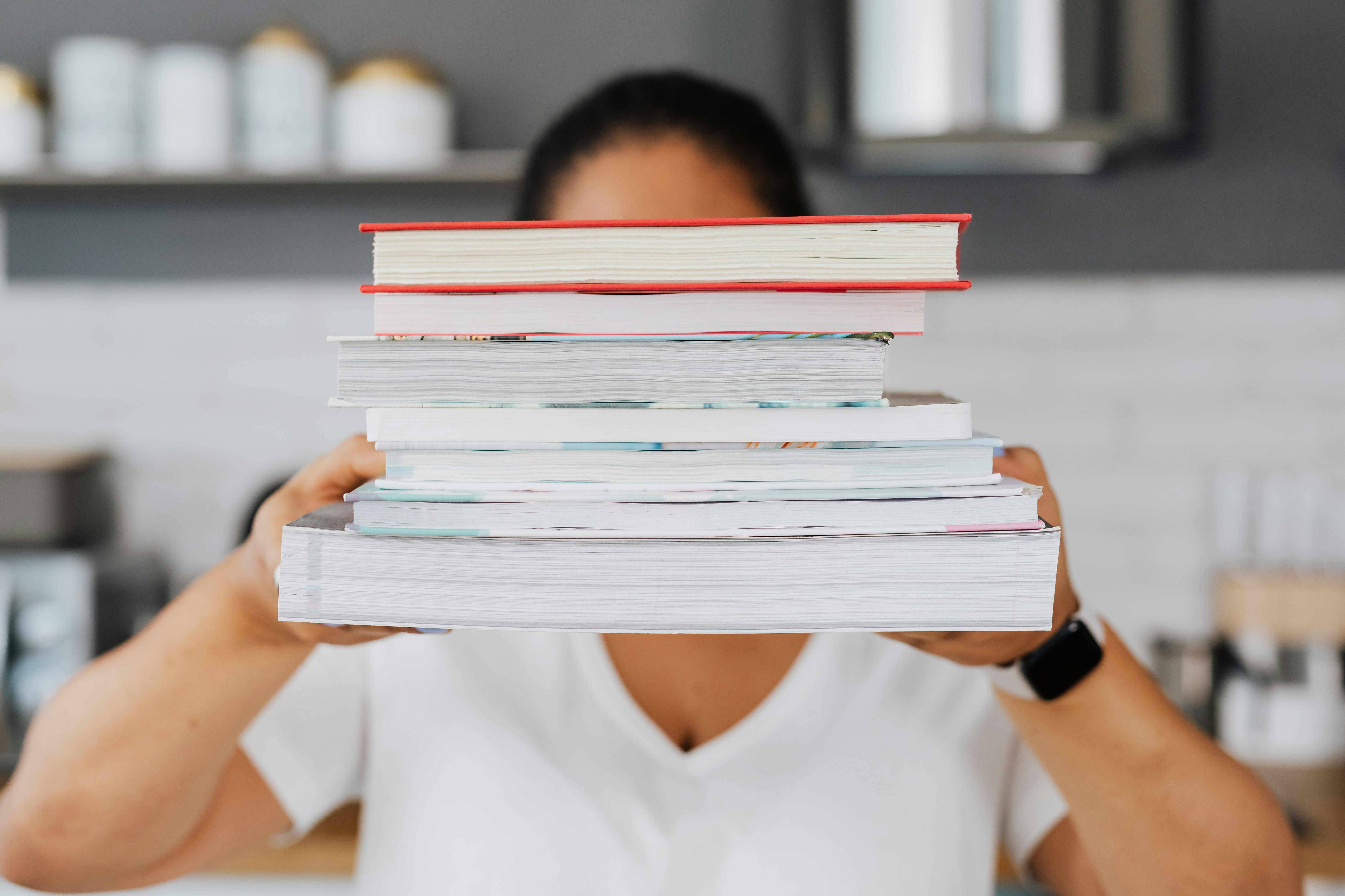 A Person Holding a Stack of Books · Free Stock Photo