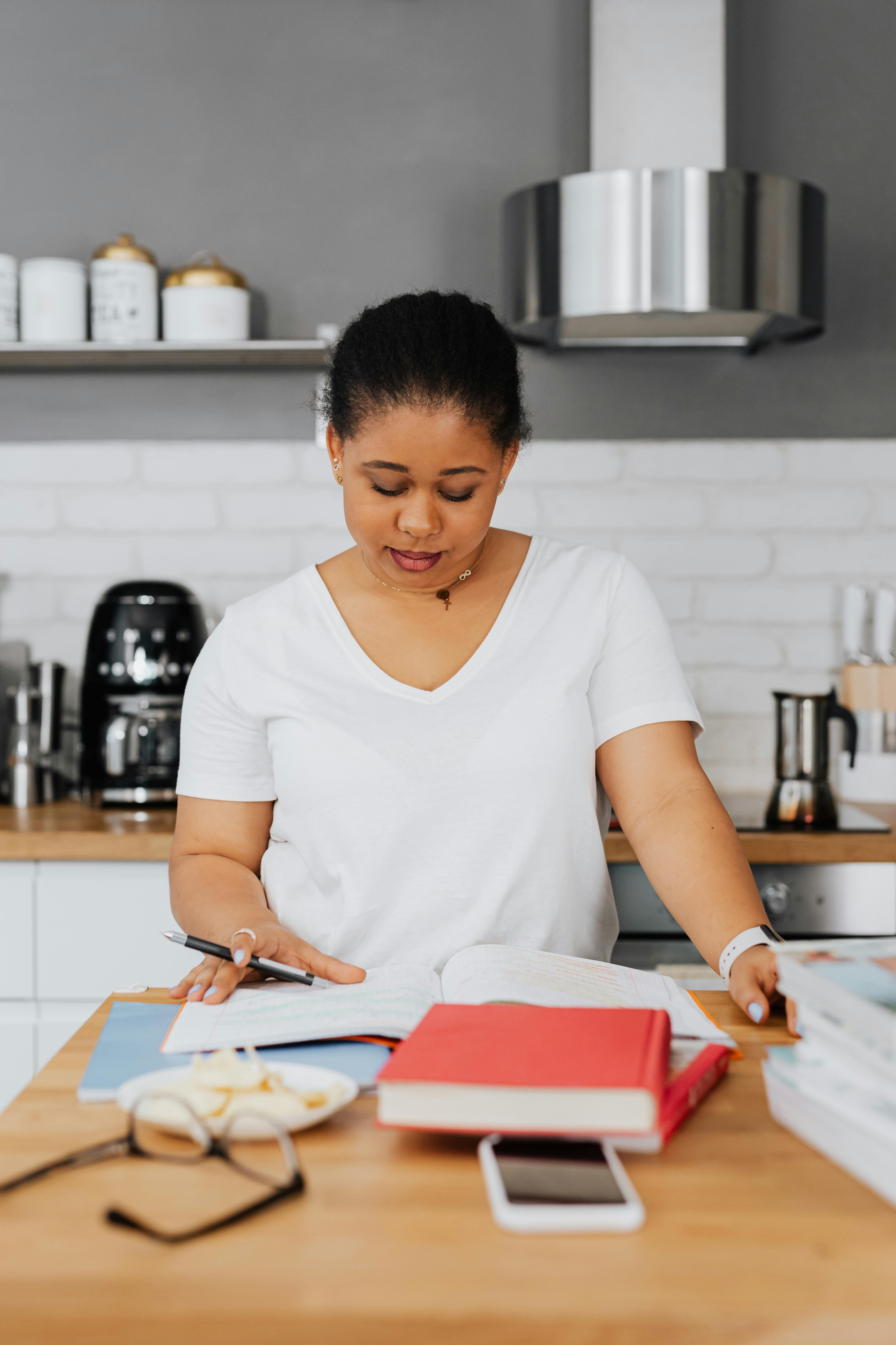 Student with Books in Kitchen · Free Stock Photo