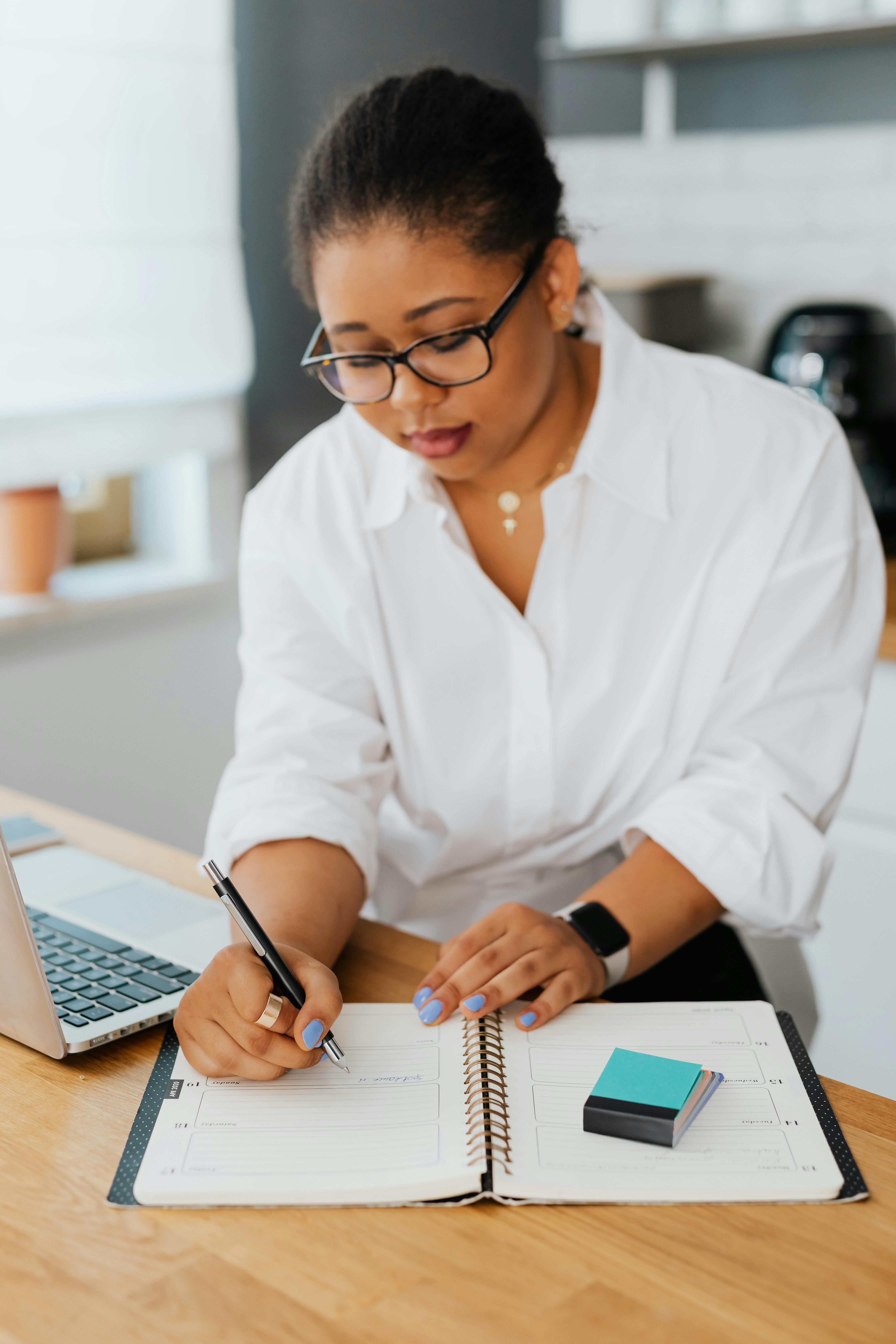Person Writing on Hanging Photos · Free Stock Photo