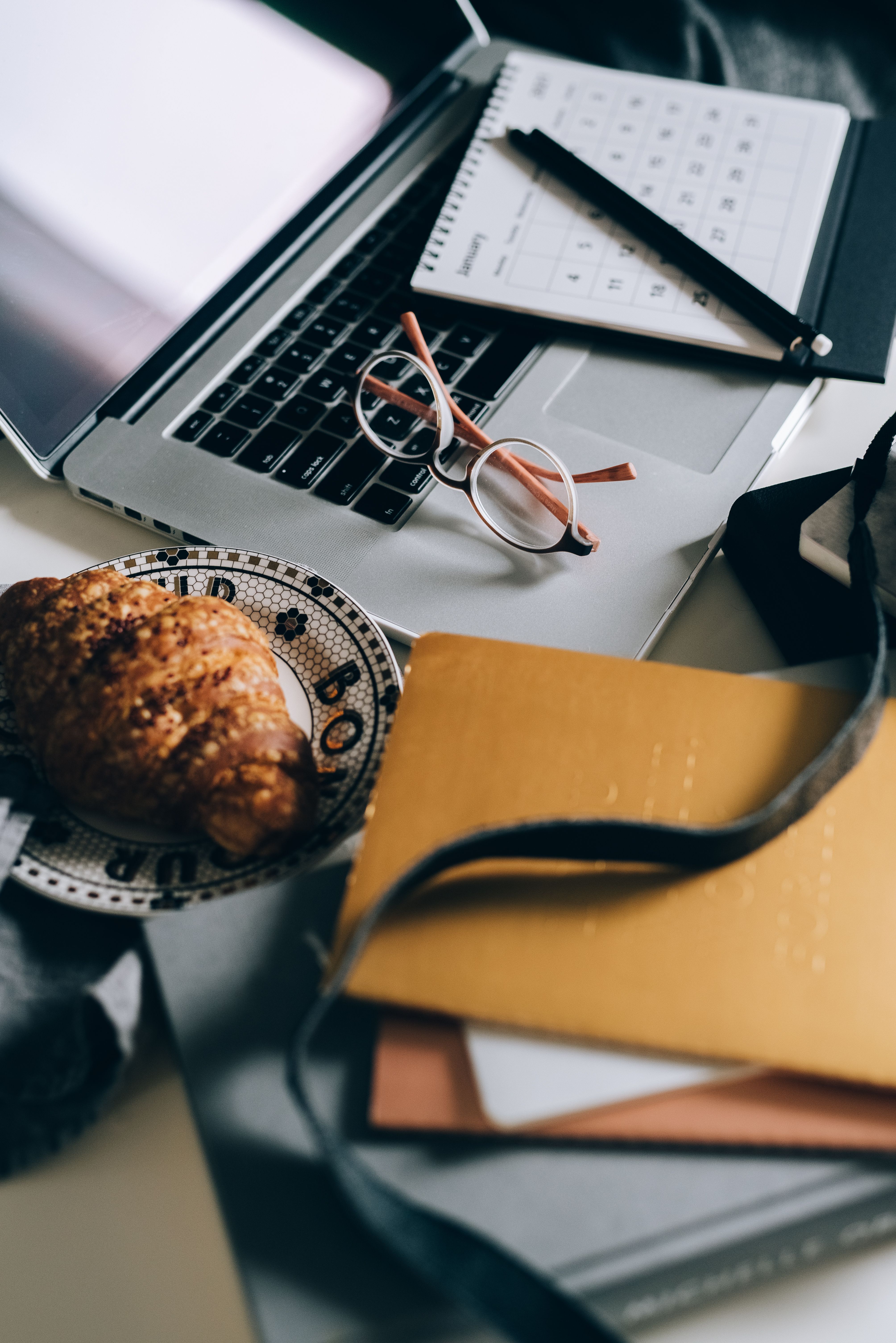 Eyeglasses and Croissant by Laptop on Desk · Free Stock Photo