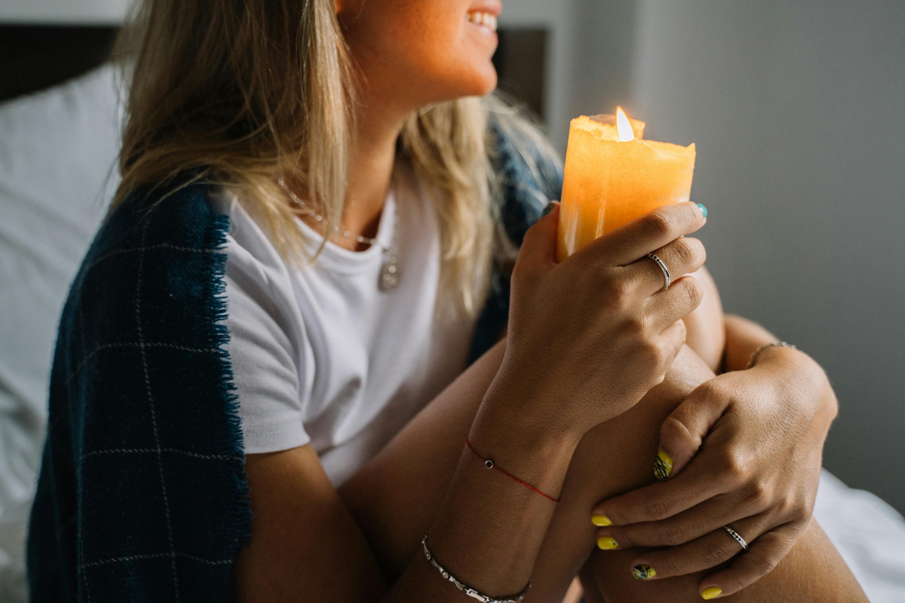 Blonde Woman Sitting with Burning Candle on Sofa · Free Stock Photo