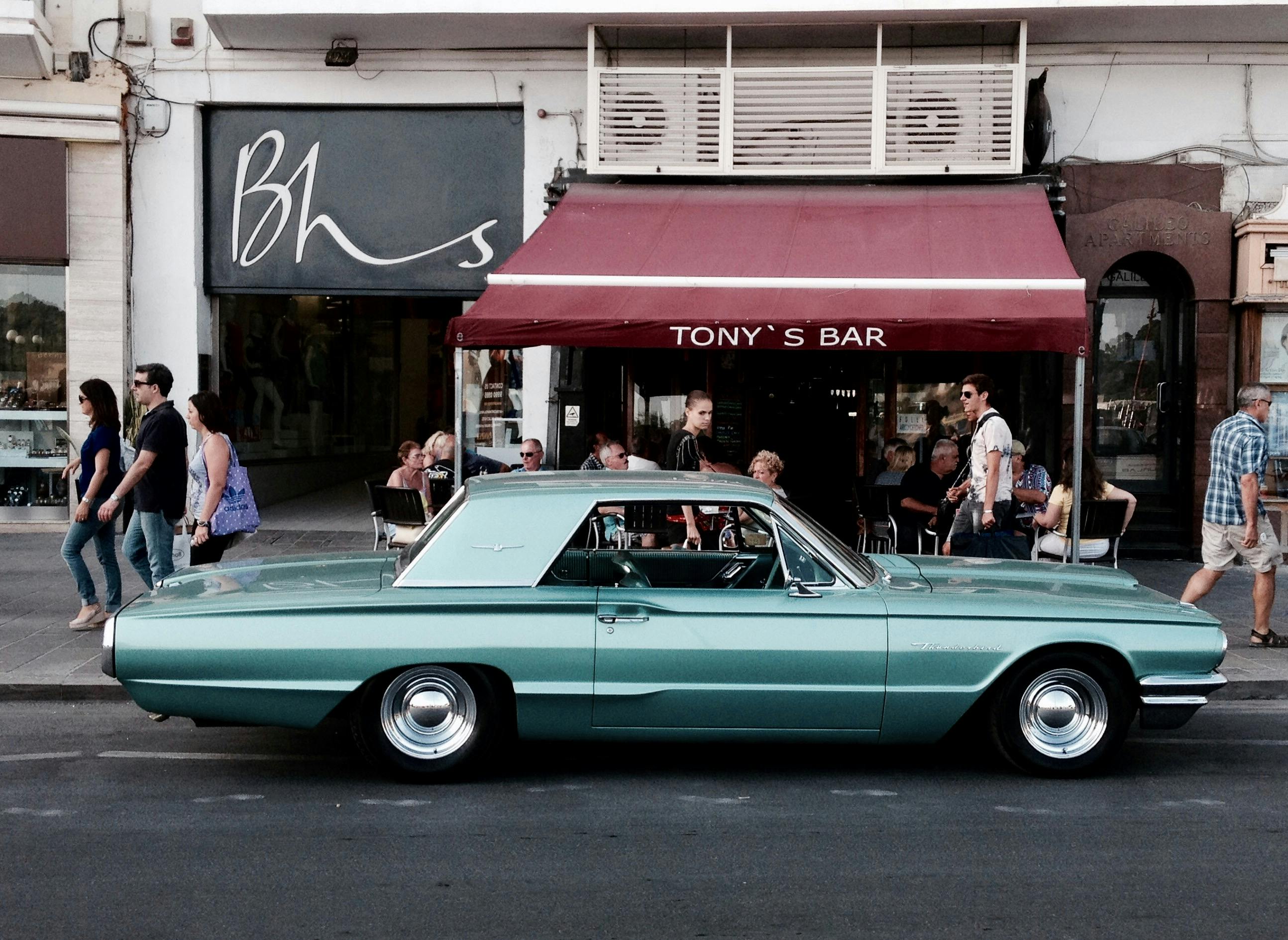 Teal Car Parked in Front of a Bar · Free Stock Photo