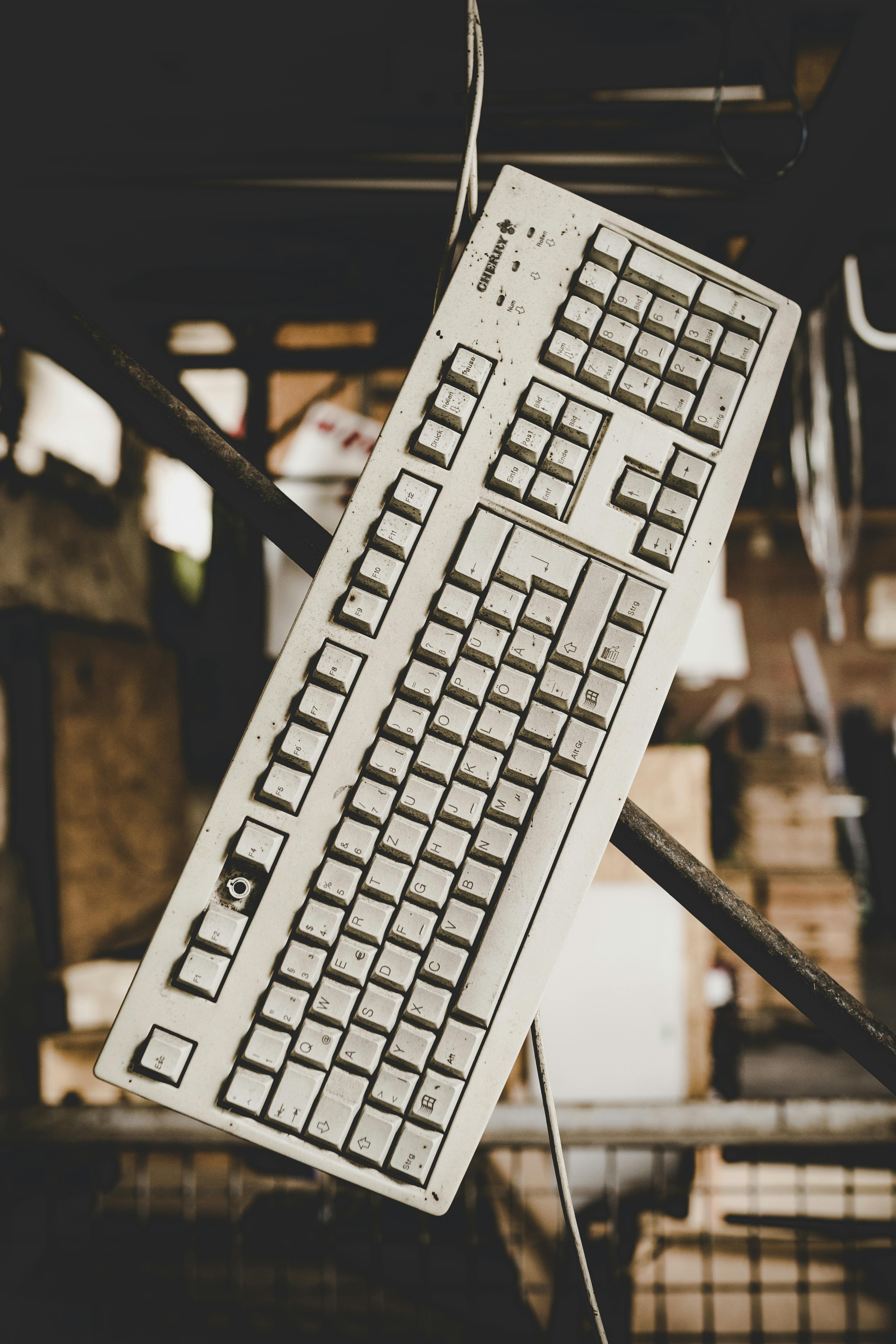 Close-Up Shot of a Hanging White Keyboard · Free Stock Photo