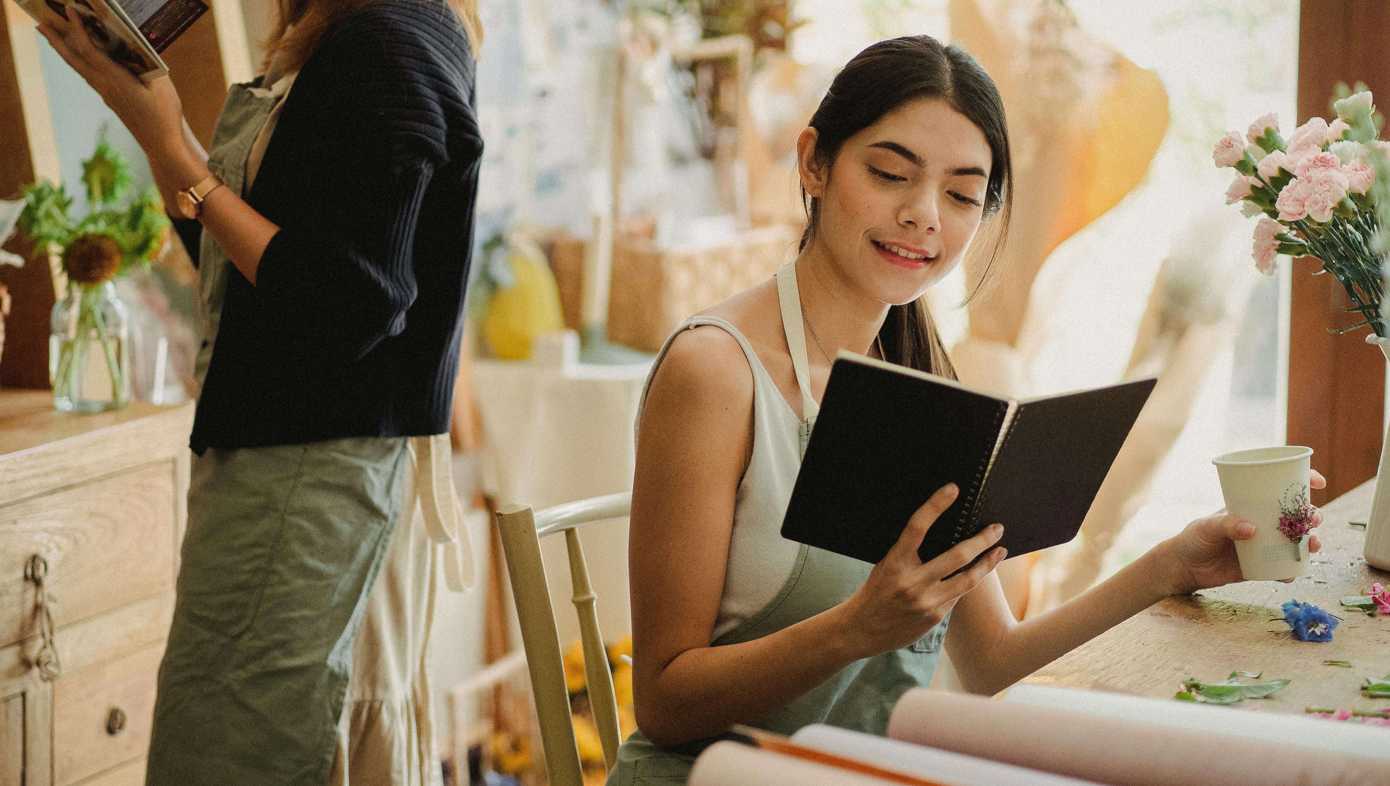 Young woman reading notes in floral shop · Free Stock Photo
