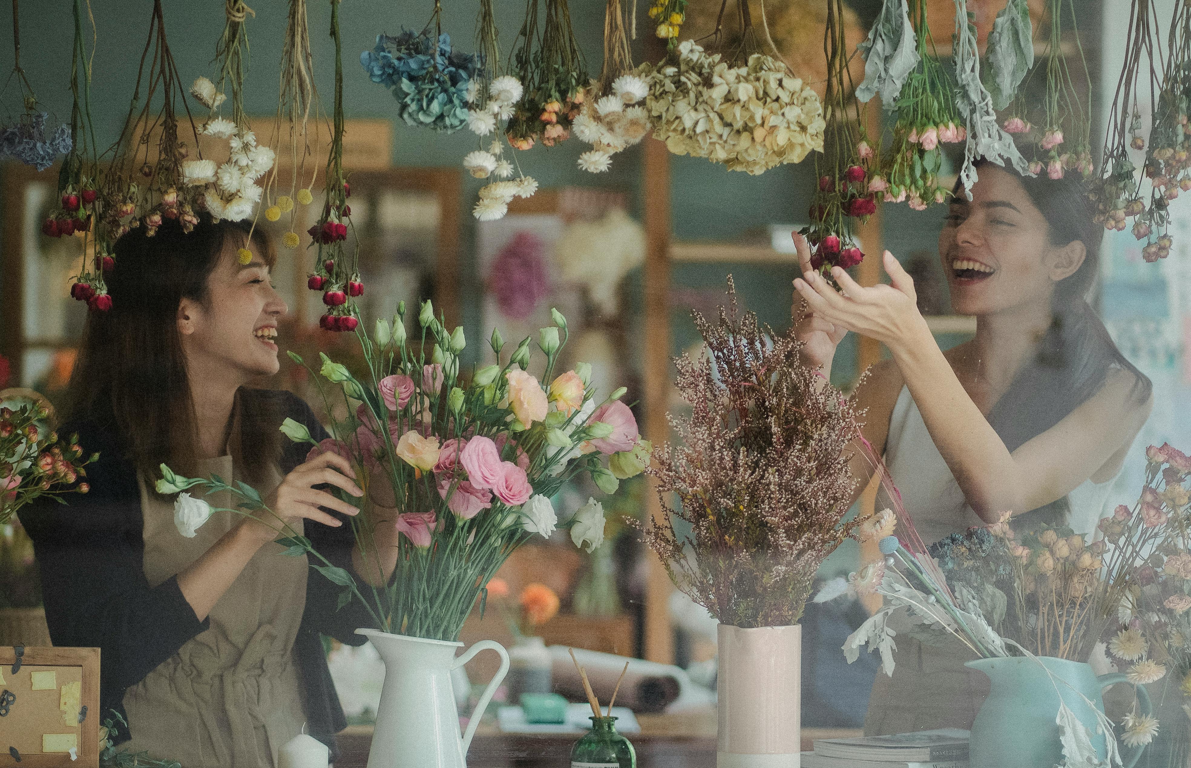 Crop ethnic florists making flower bouquet at work · Free Stock Photo