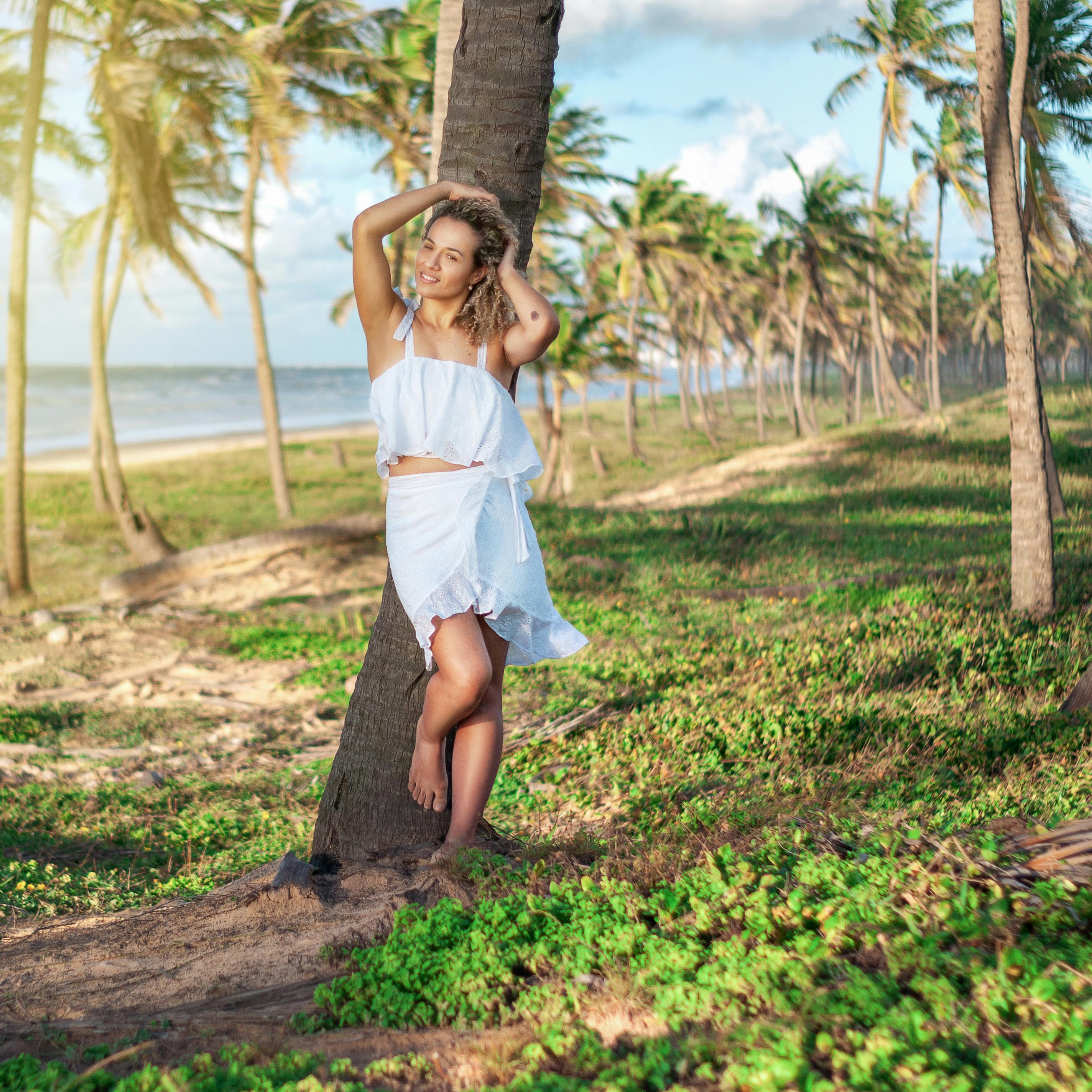 A Girl Standing on Coconut Tree Trunk · Free Stock Photo