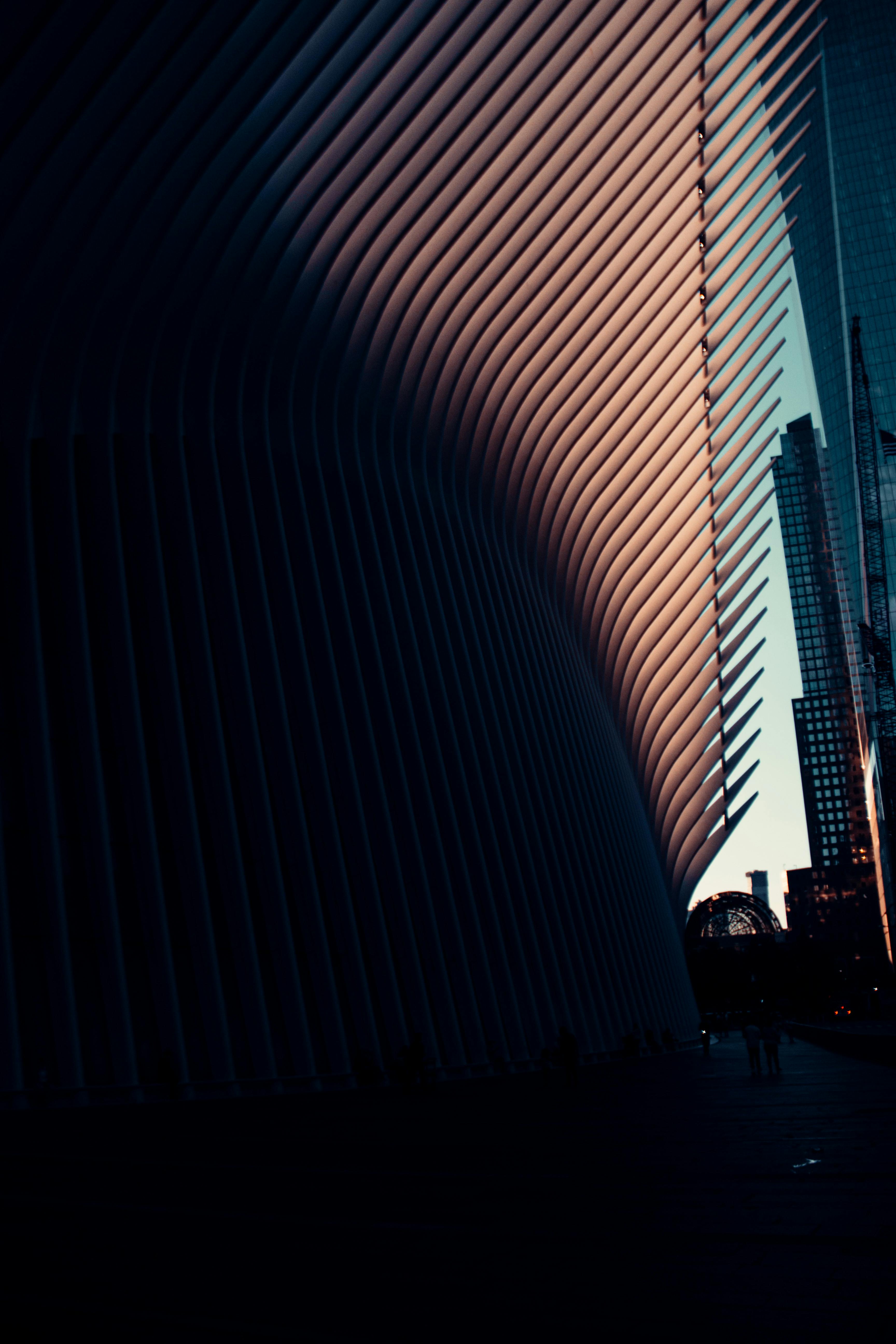 Ribbed fence near modern skyscraper facades in town · Free Stock Photo