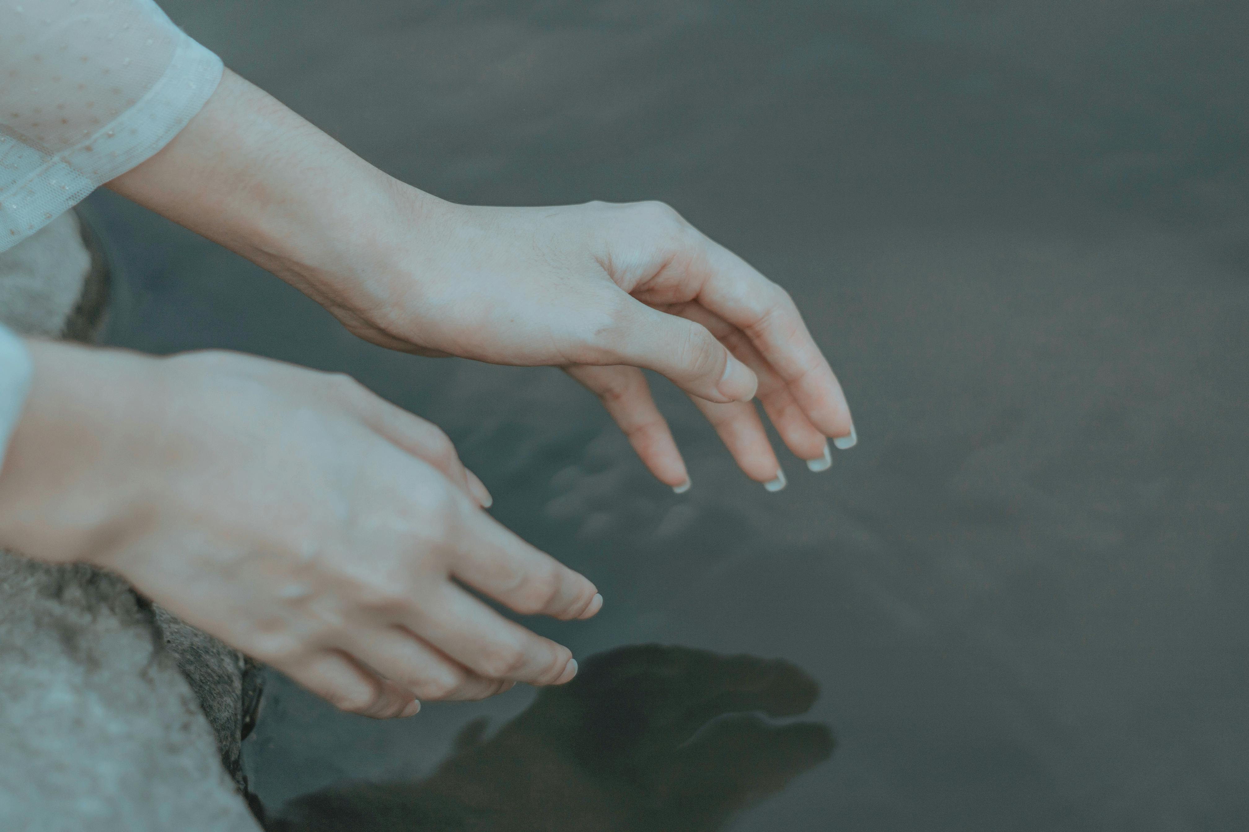 Woman reaching to calm water · Free Stock Photo