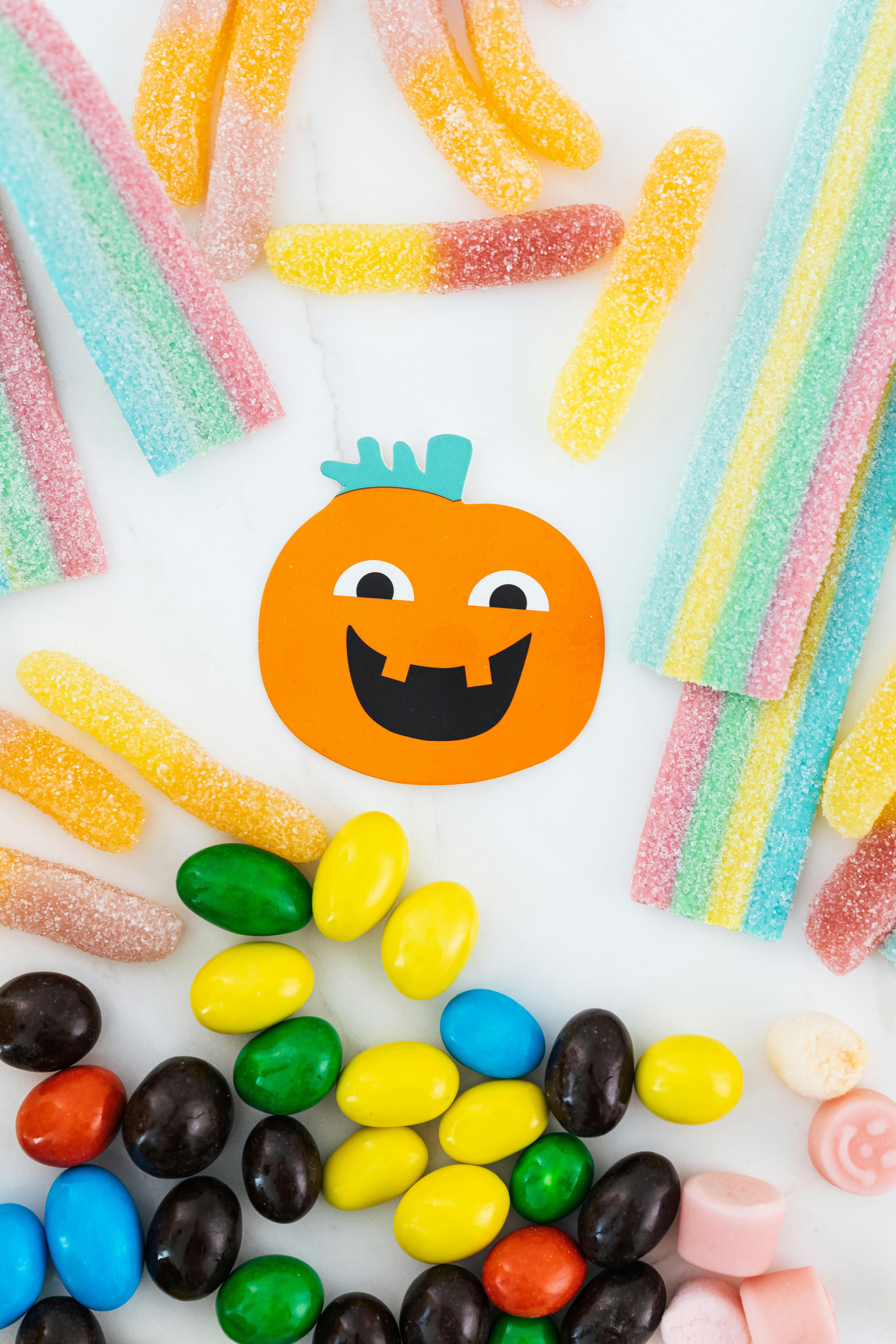 Funny face made of colorful yummy worn sweets against beige background ...