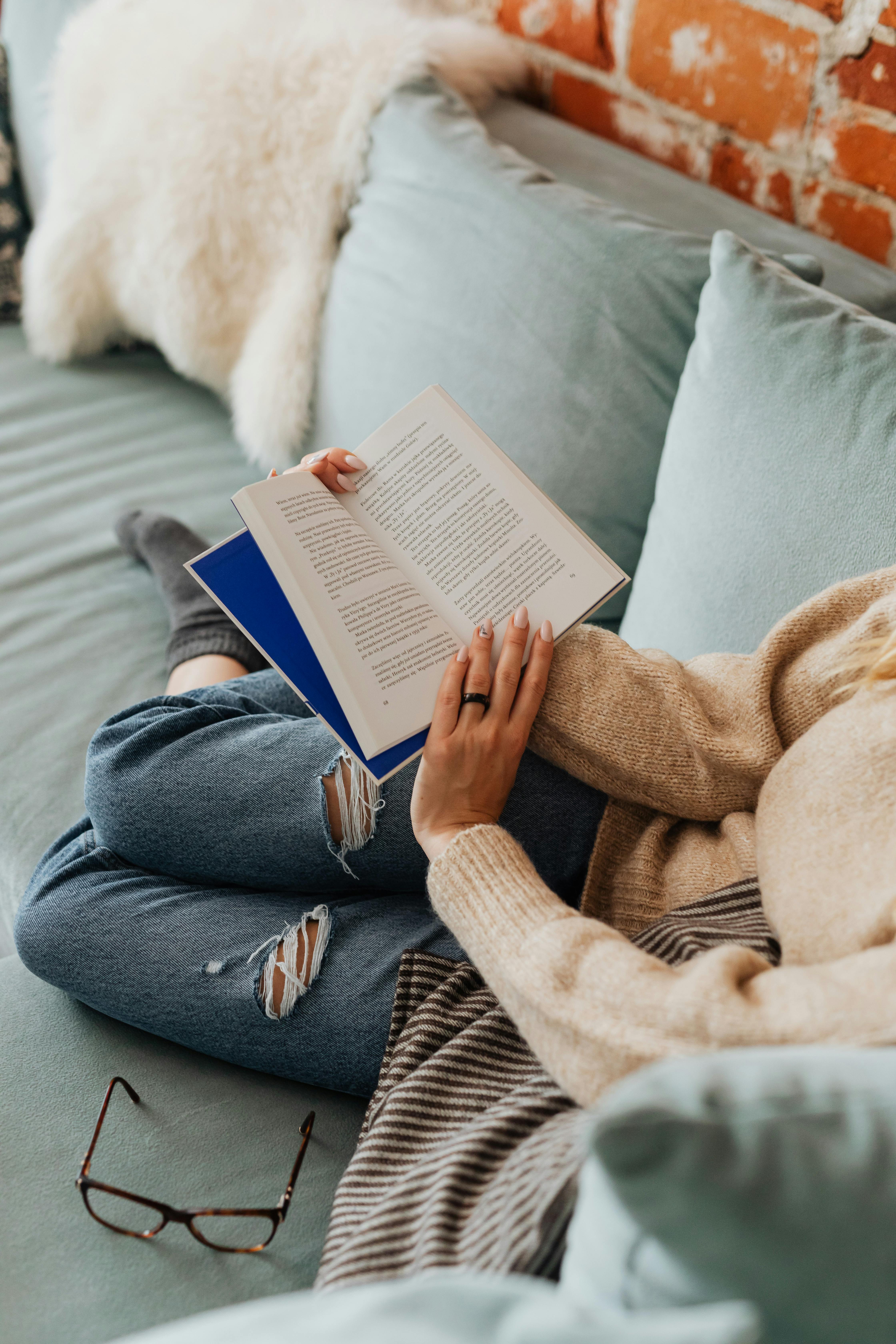Person Laying on Sofa While Reading Book · Free Stock Photo