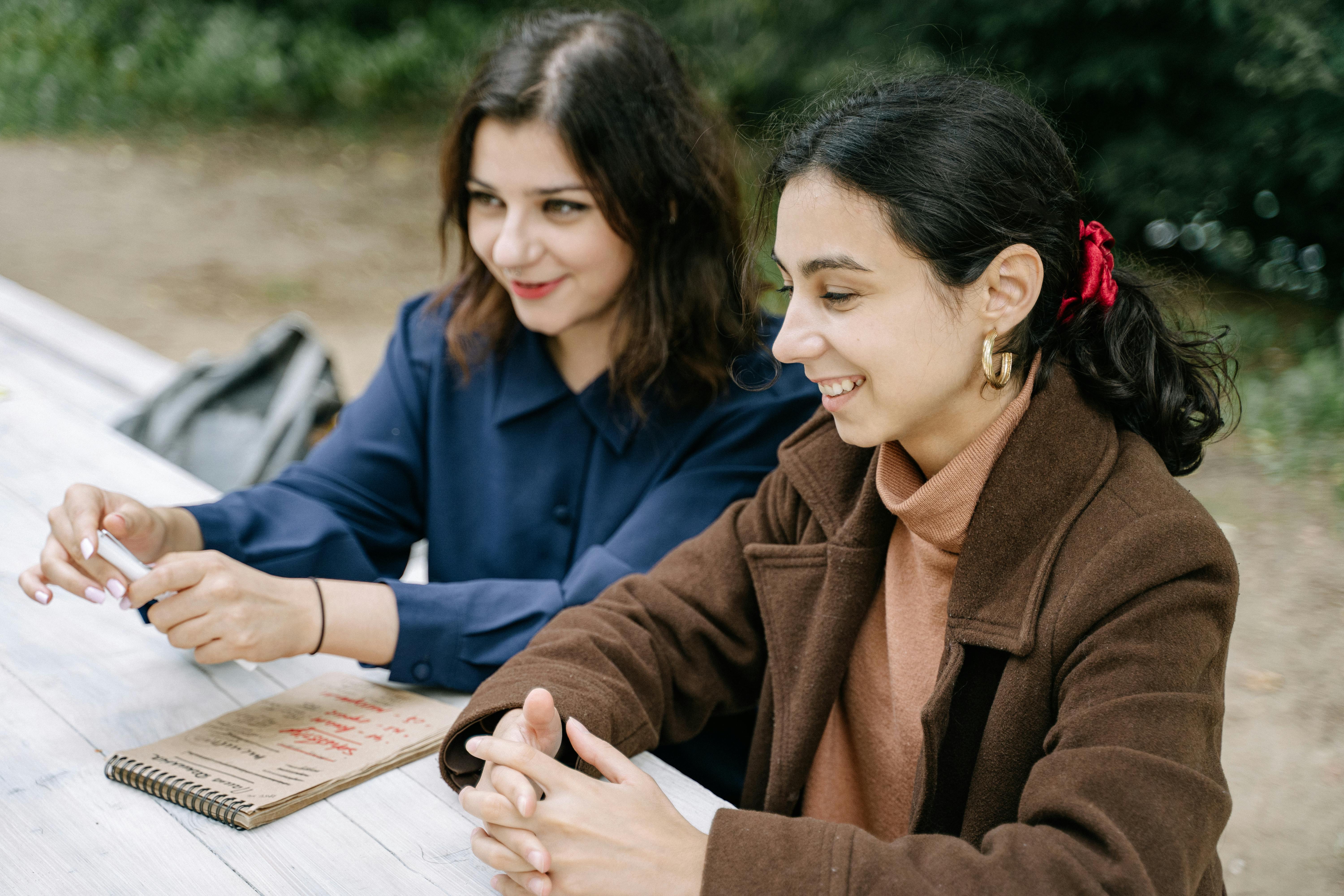 Female Friends sitting beside each other · Free Stock Photo