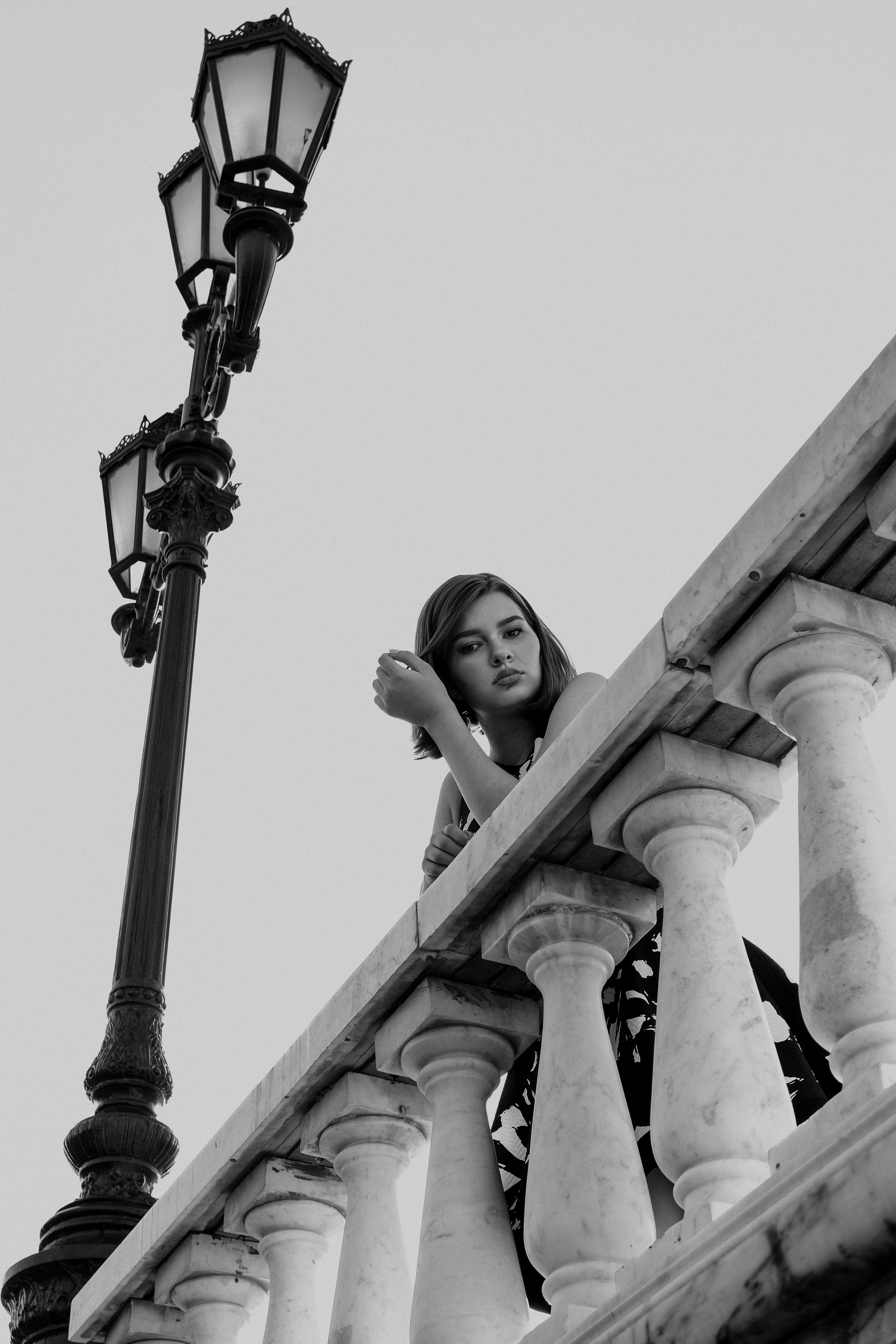 Young woman leaning on stone railing · Free Stock Photo