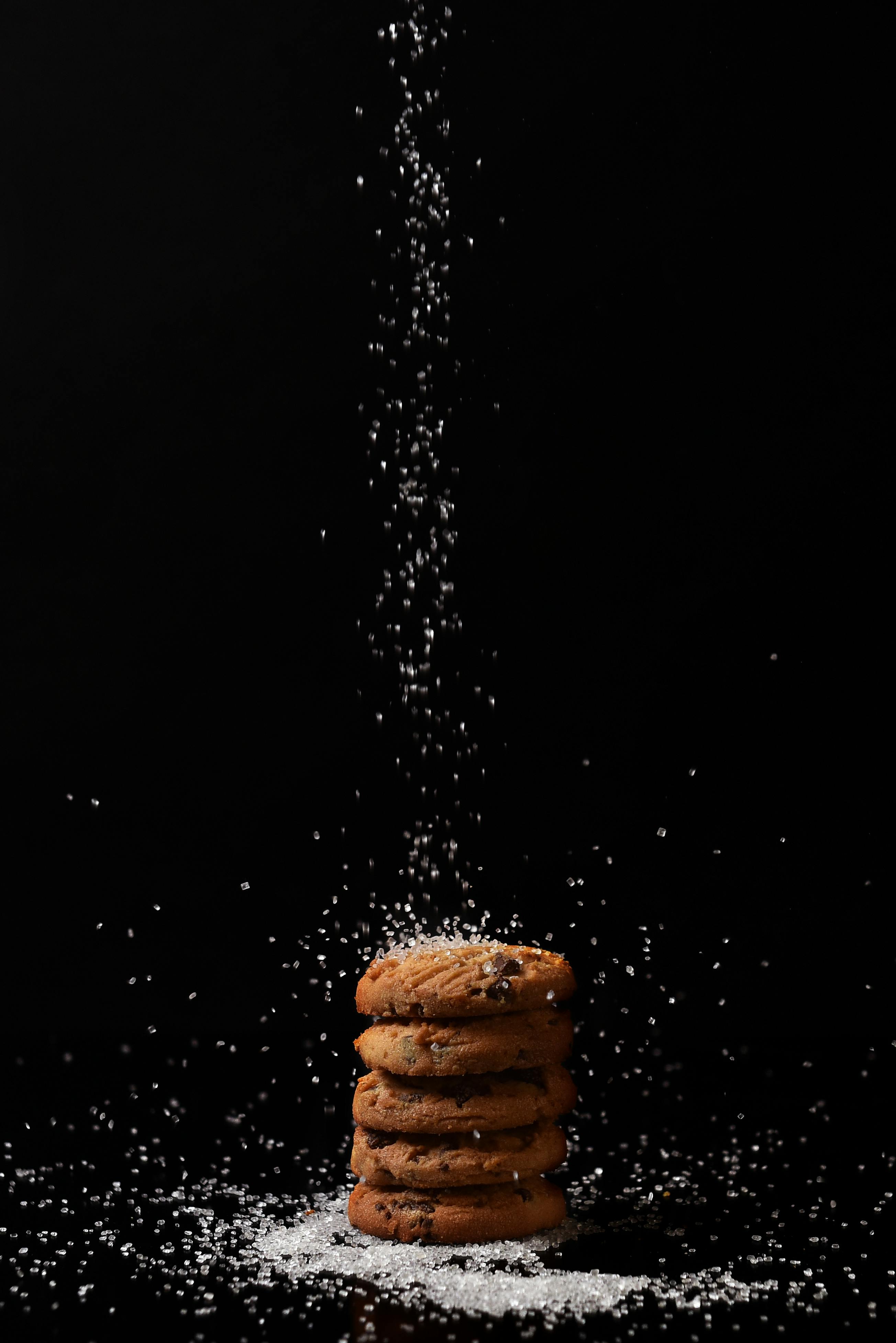 Dropping of Sugar on Stacked Cookies · Free Stock Photo