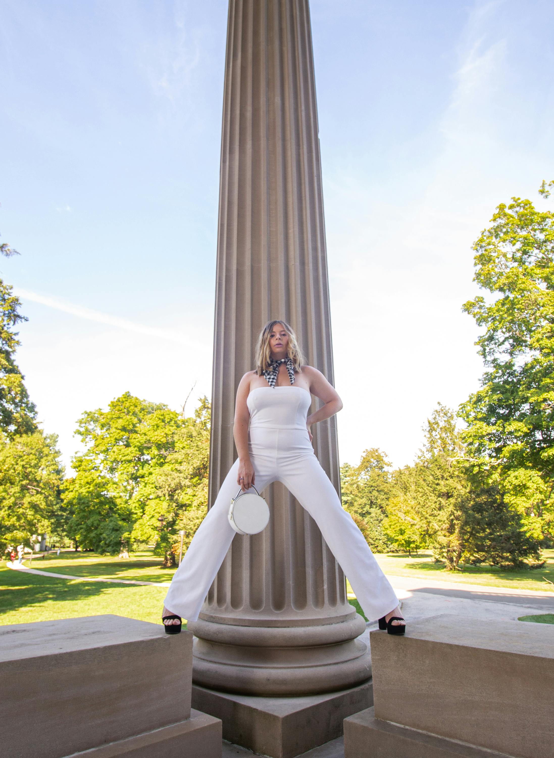Woman in Black Suit Standing Near Column with Eyes Closed · Free Stock ...