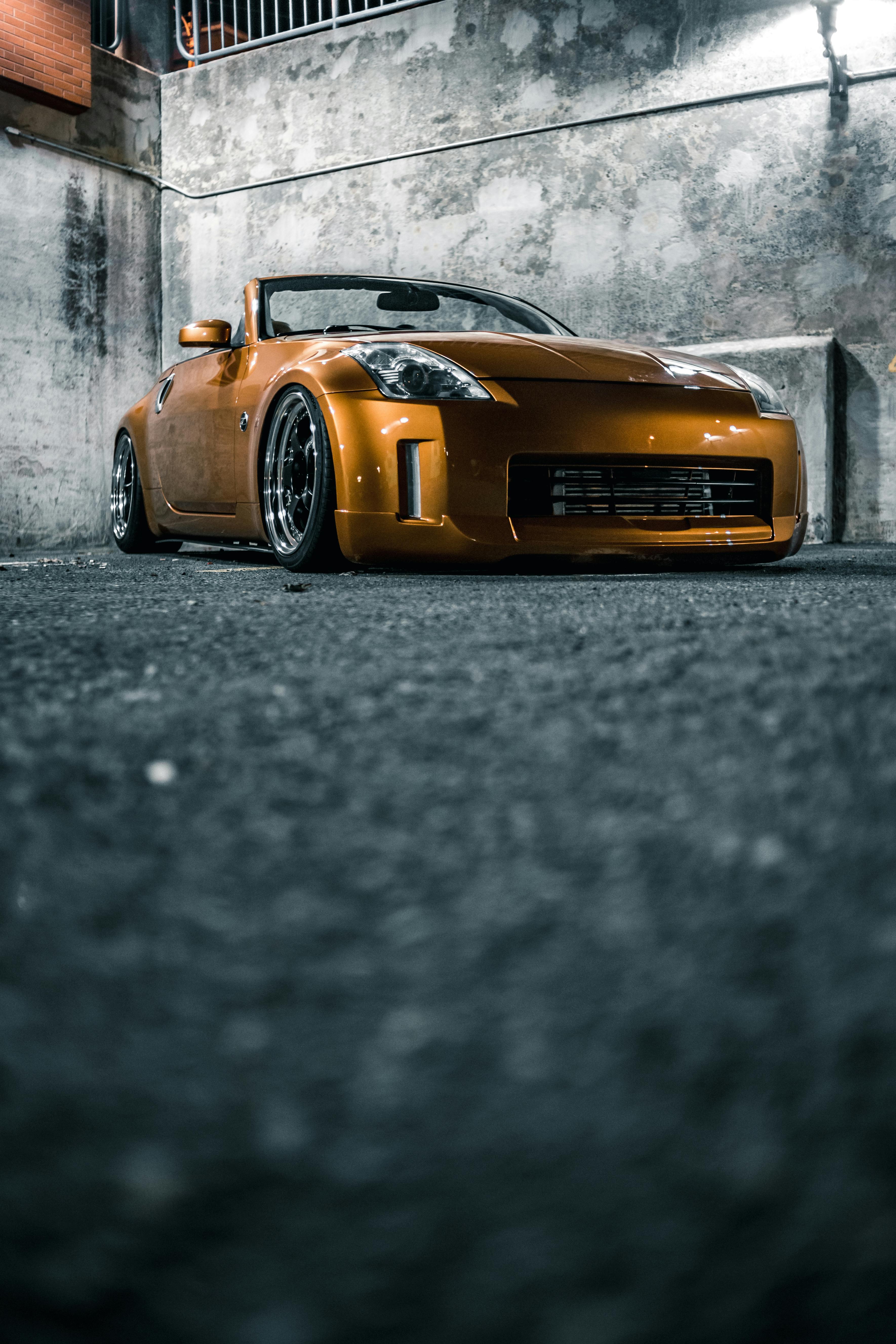 Luxury racing car on rough pavement at dusk · Free Stock Photo