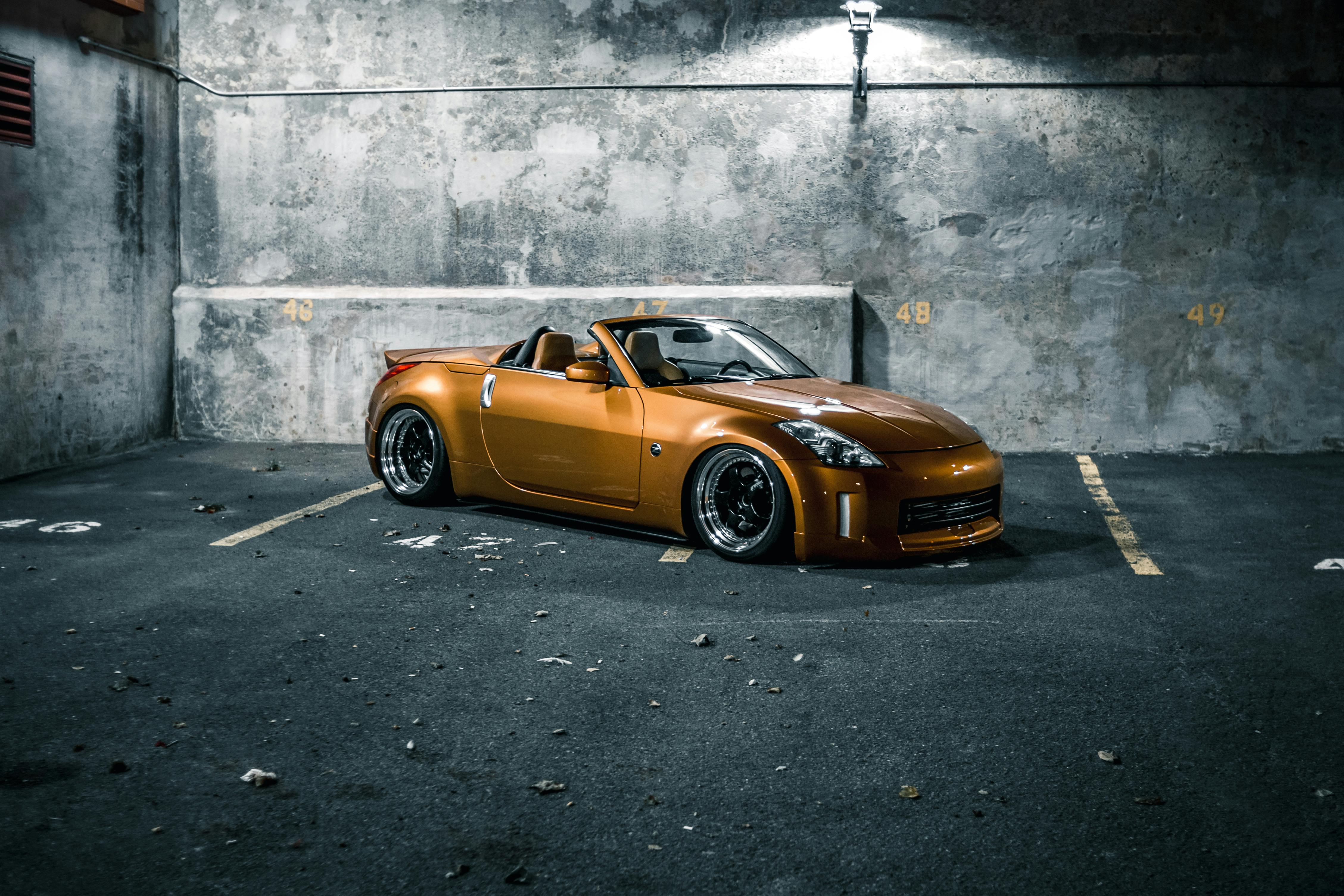 Modern racing car on pavement near shabby wall at night · Free Stock Photo