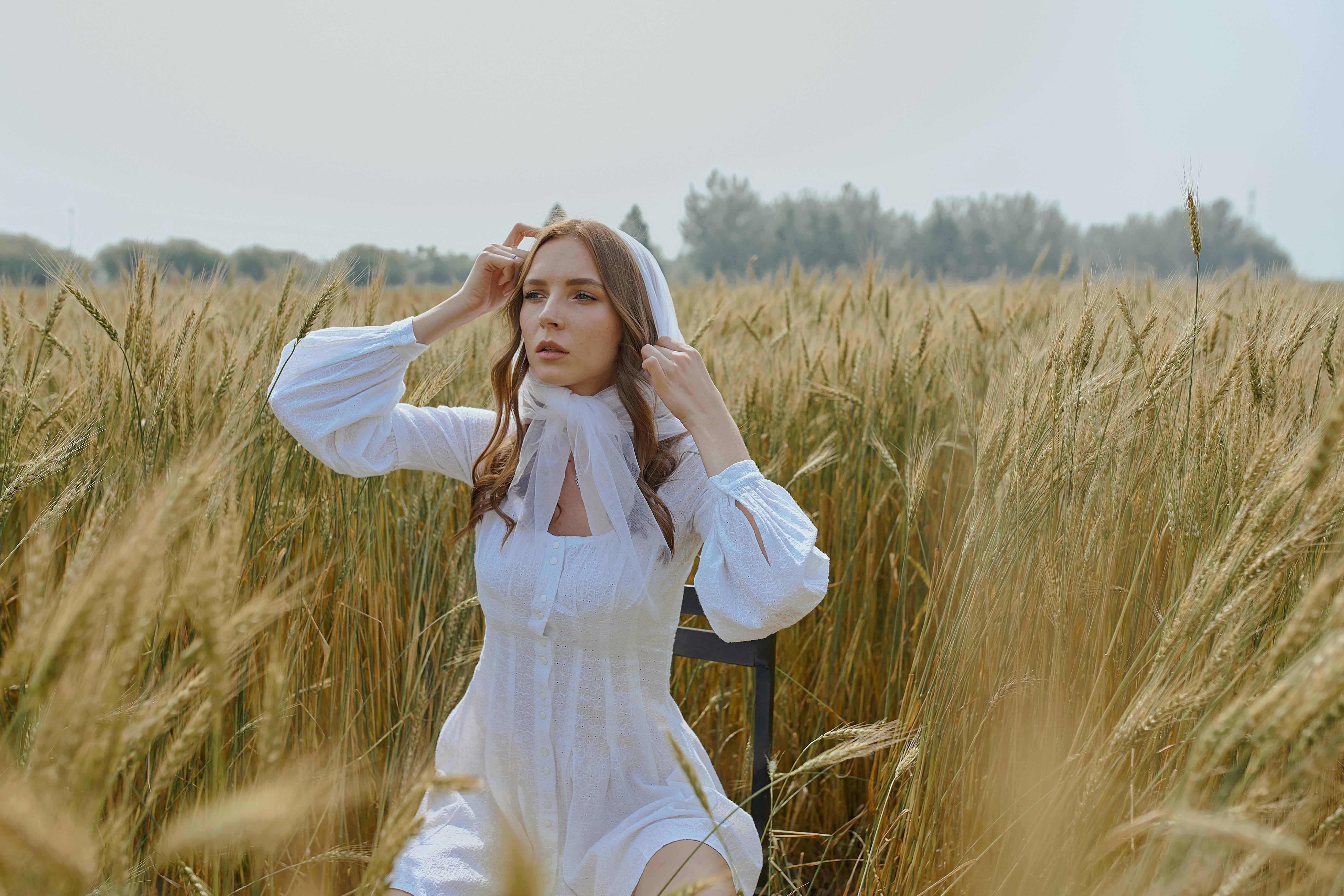 Stylish woman sitting on chair on agricultural field · Free Stock Photo