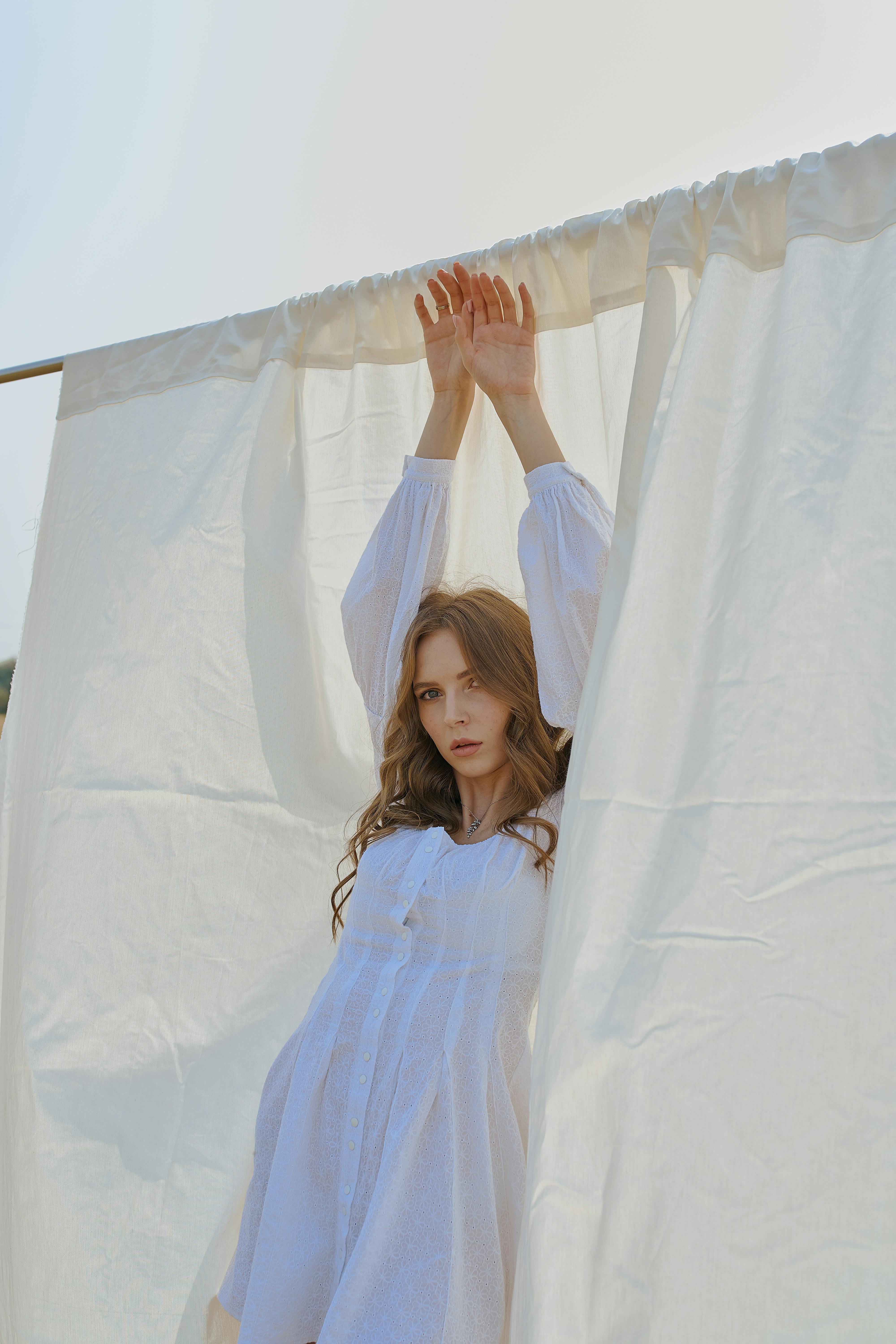 Charming model standing against white sheet in nature · Free Stock Photo