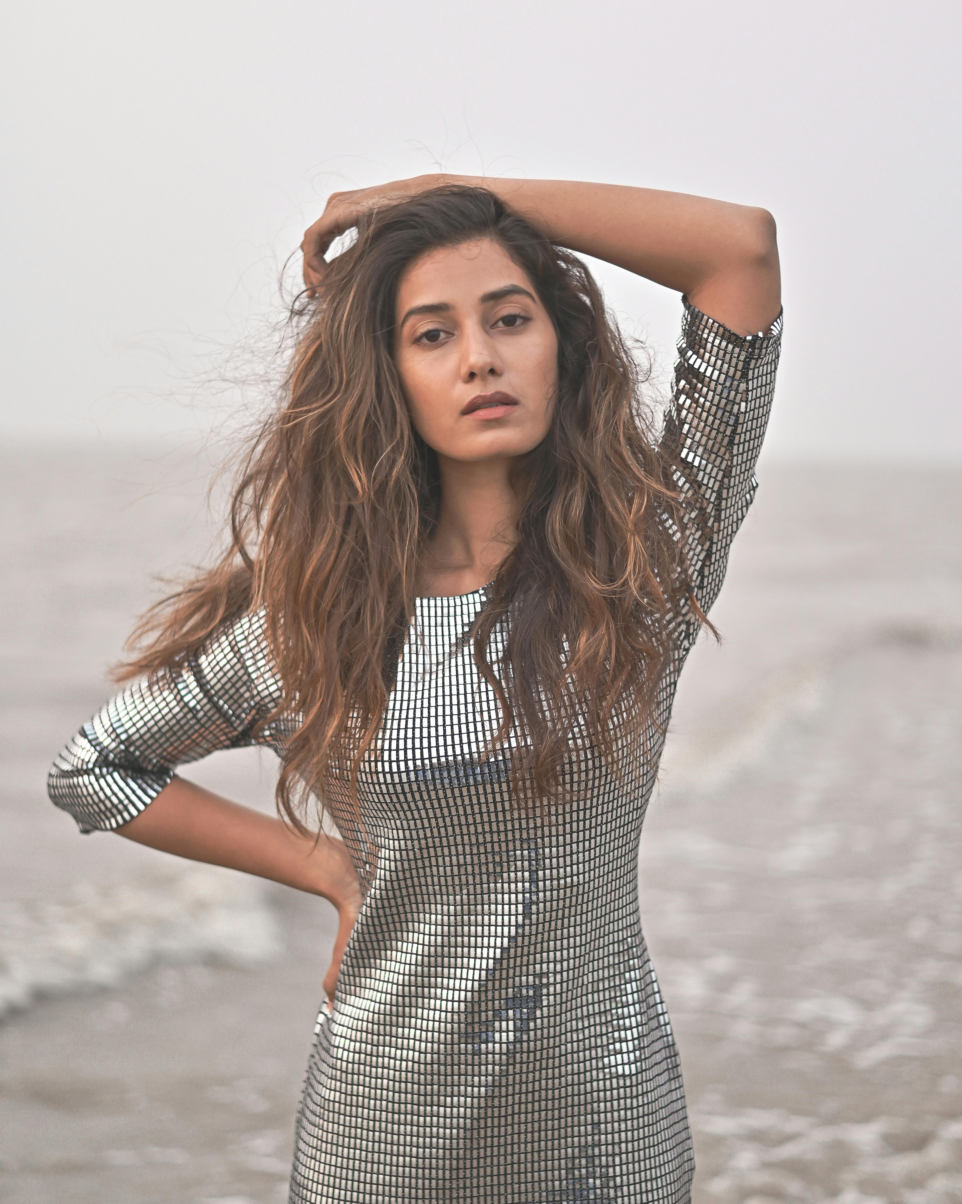 Stylish ethnic model near stormy ocean under sky · Free Stock Photo