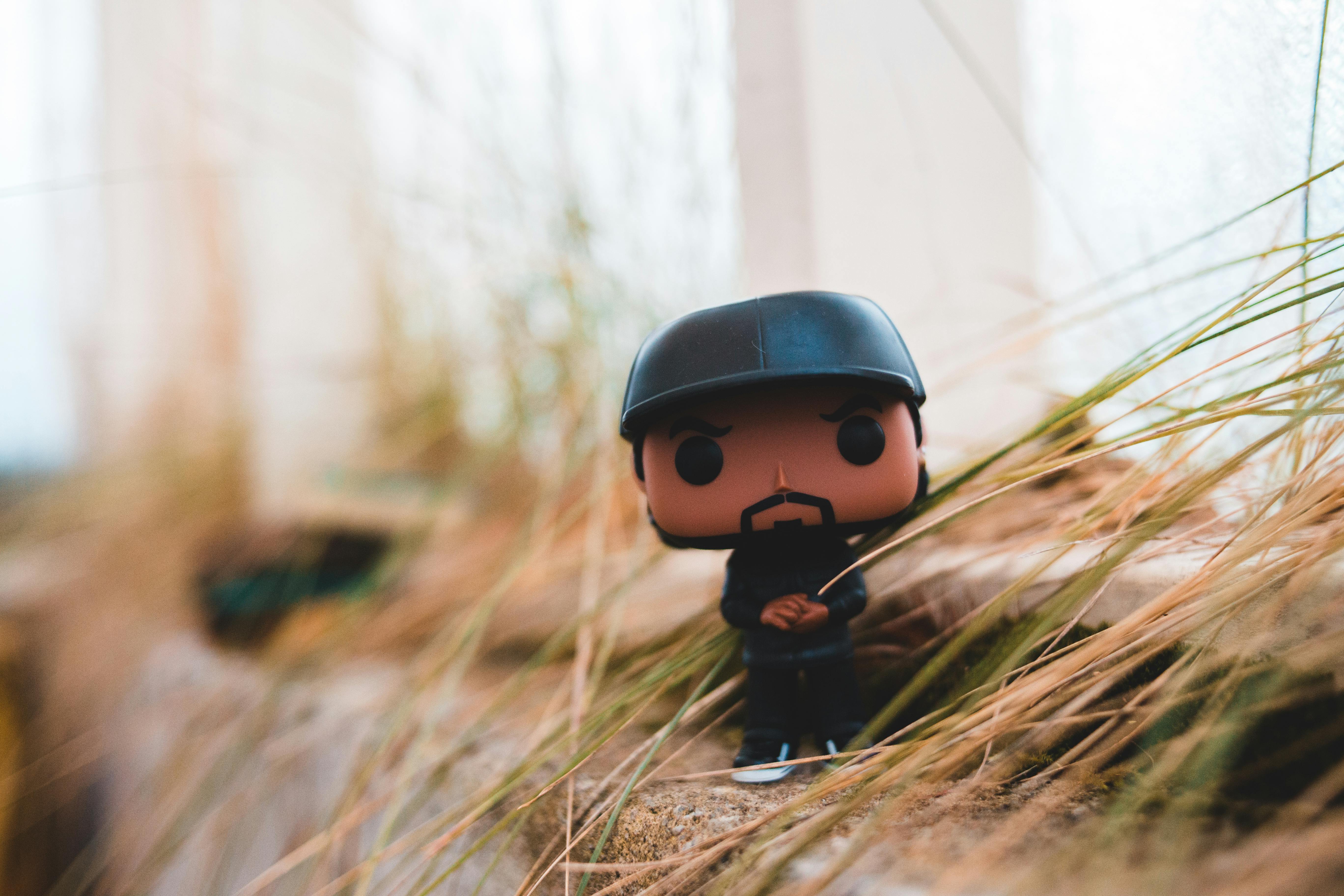 Stylish man mini toy placed on table near dry grass · Free Stock Photo