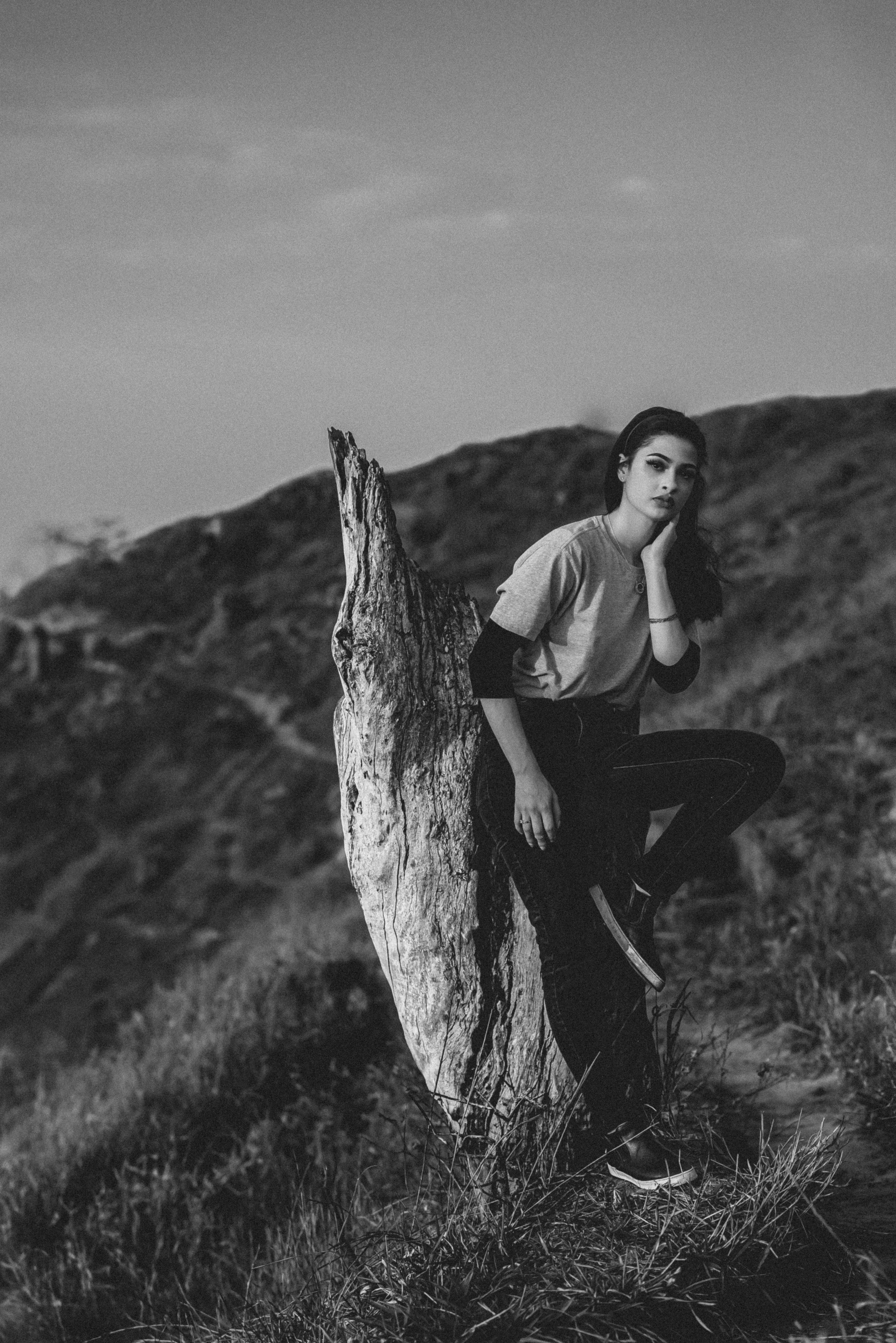 Woman leaning to stump on slope · Free Stock Photo