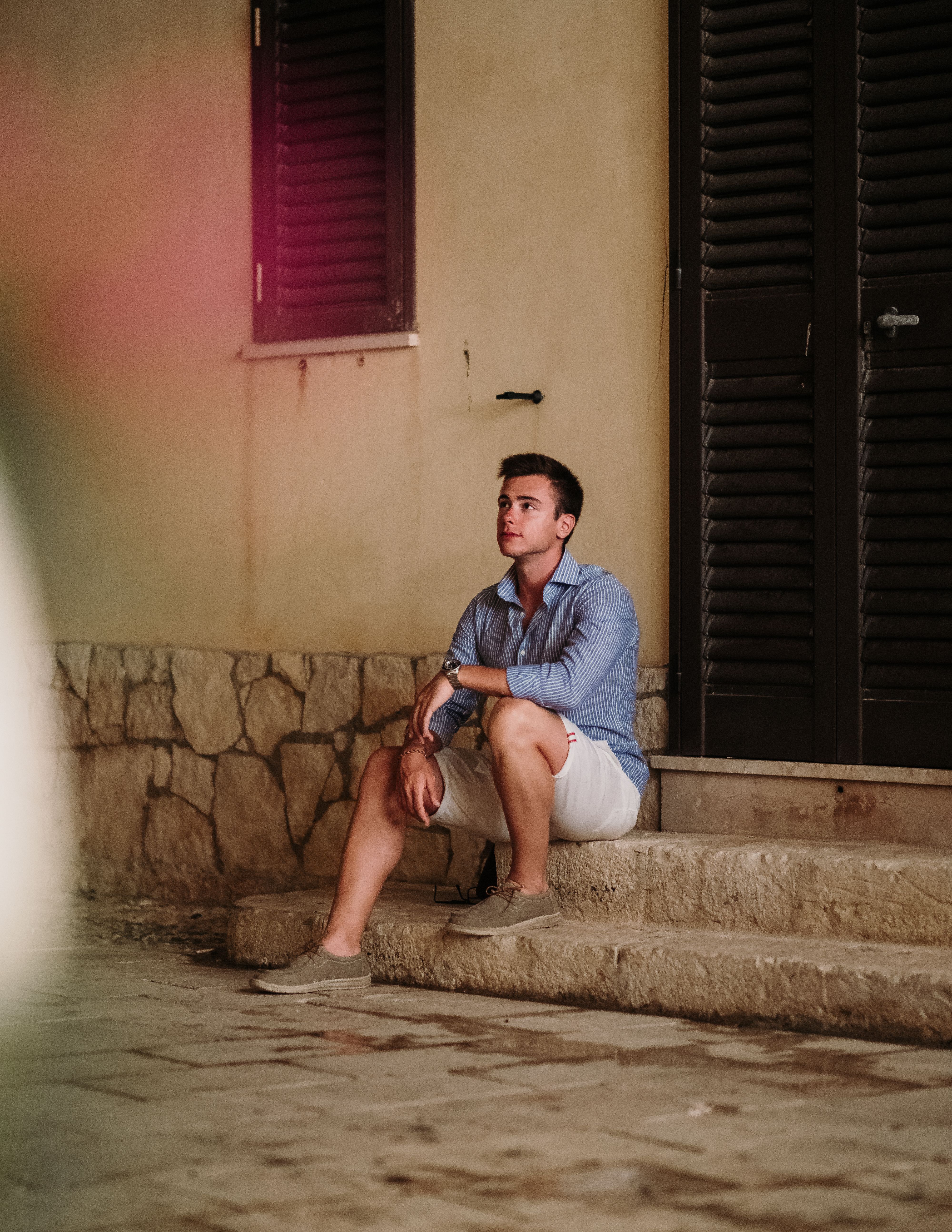 Young handsome man sitting on doorstep · Free Stock Photo