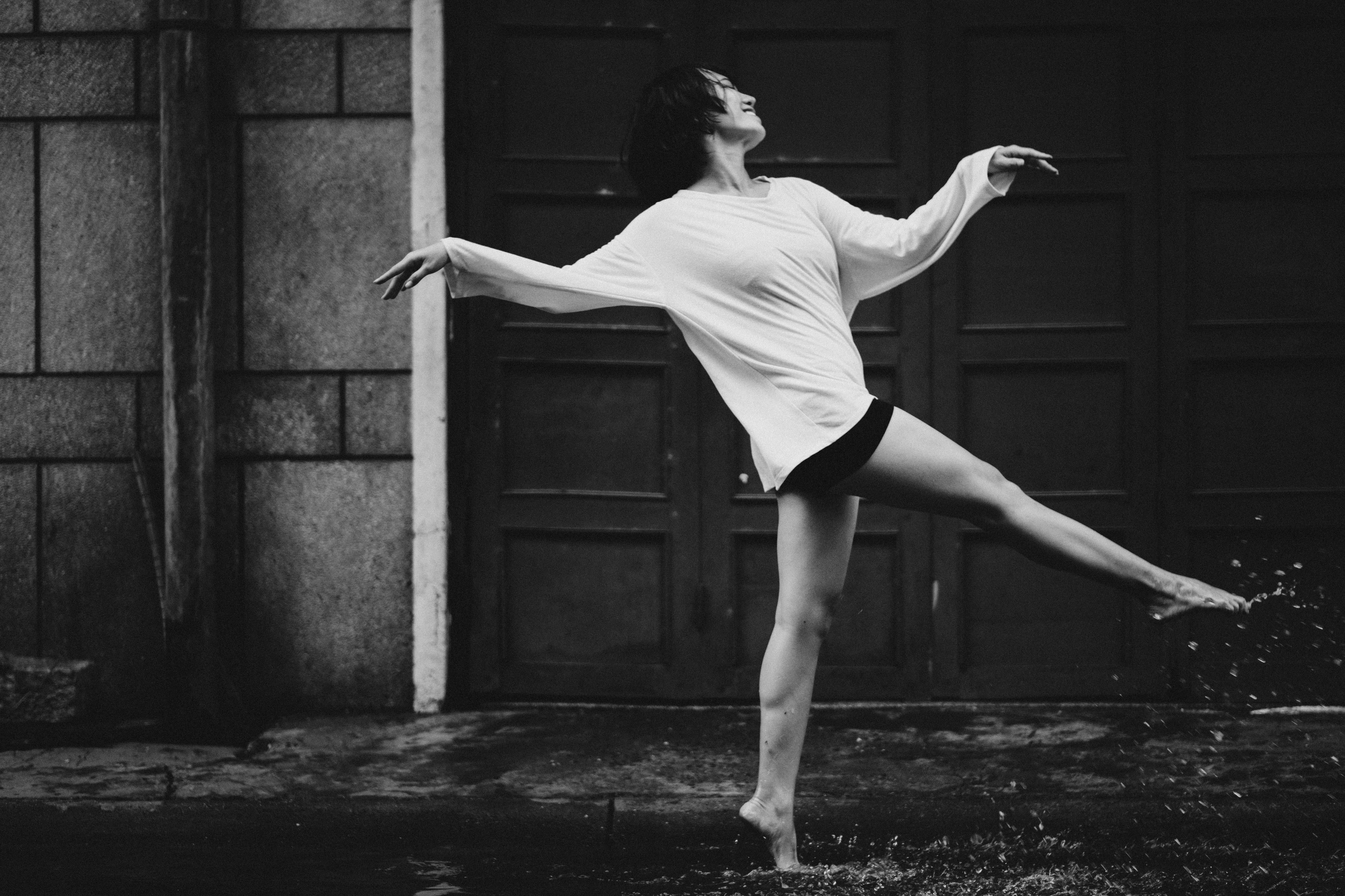 Young woman smiling brightly while splashing water on street · Free ...
