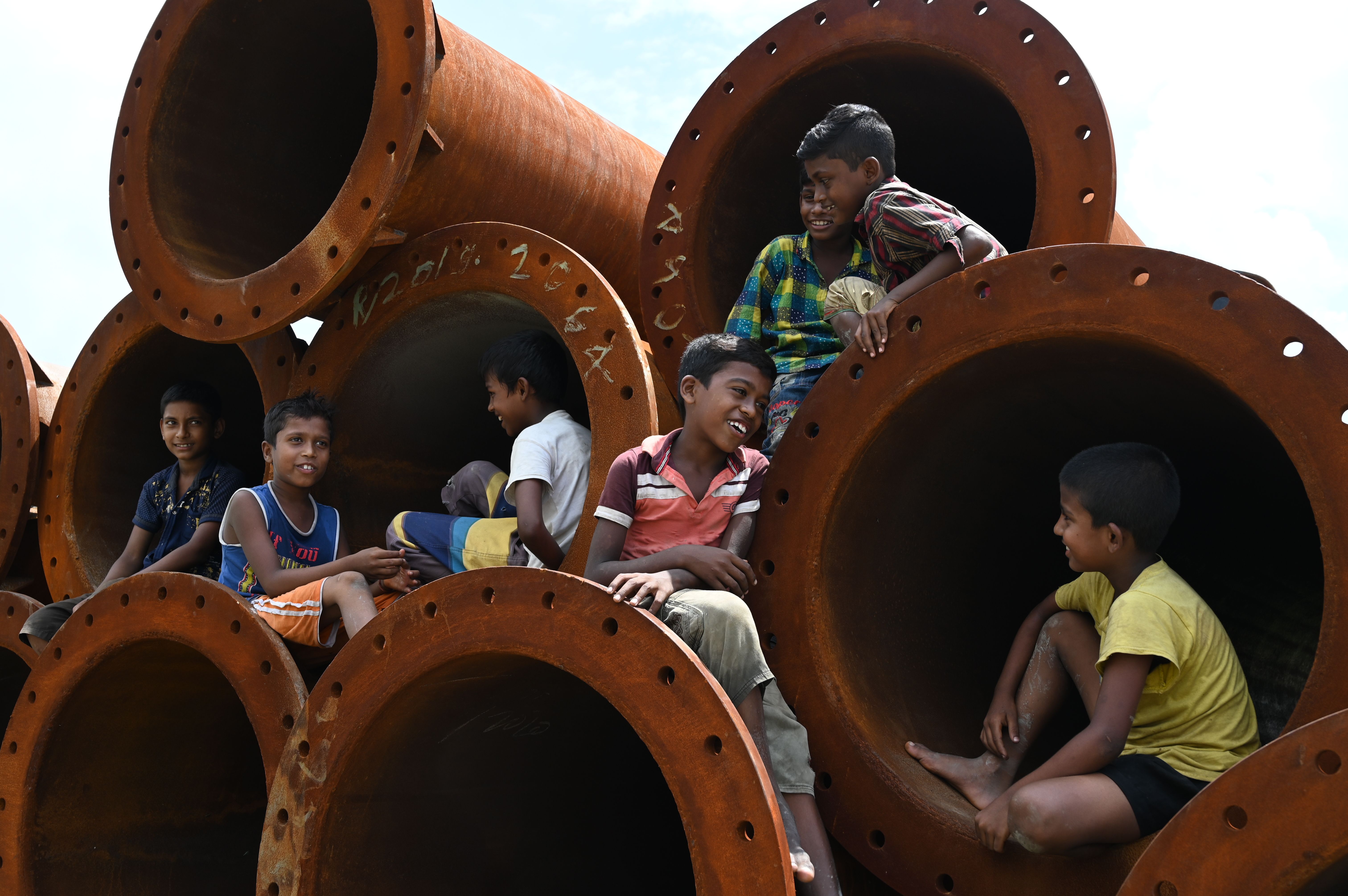 Happy Children Sitting in Industrial Pipes · Free Stock Photo