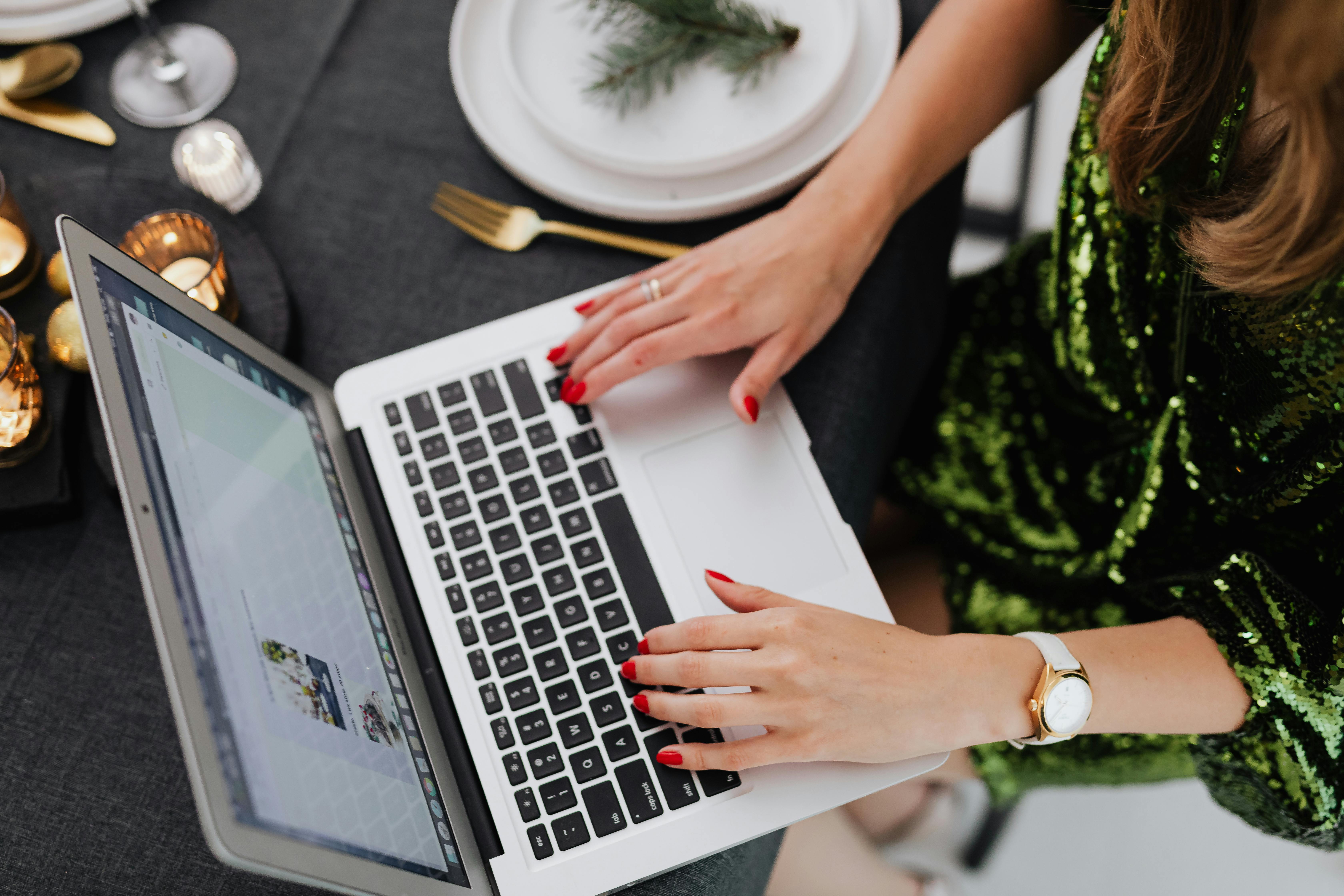 Woman Working on Laptop by Dinner Table · Free Stock Photo