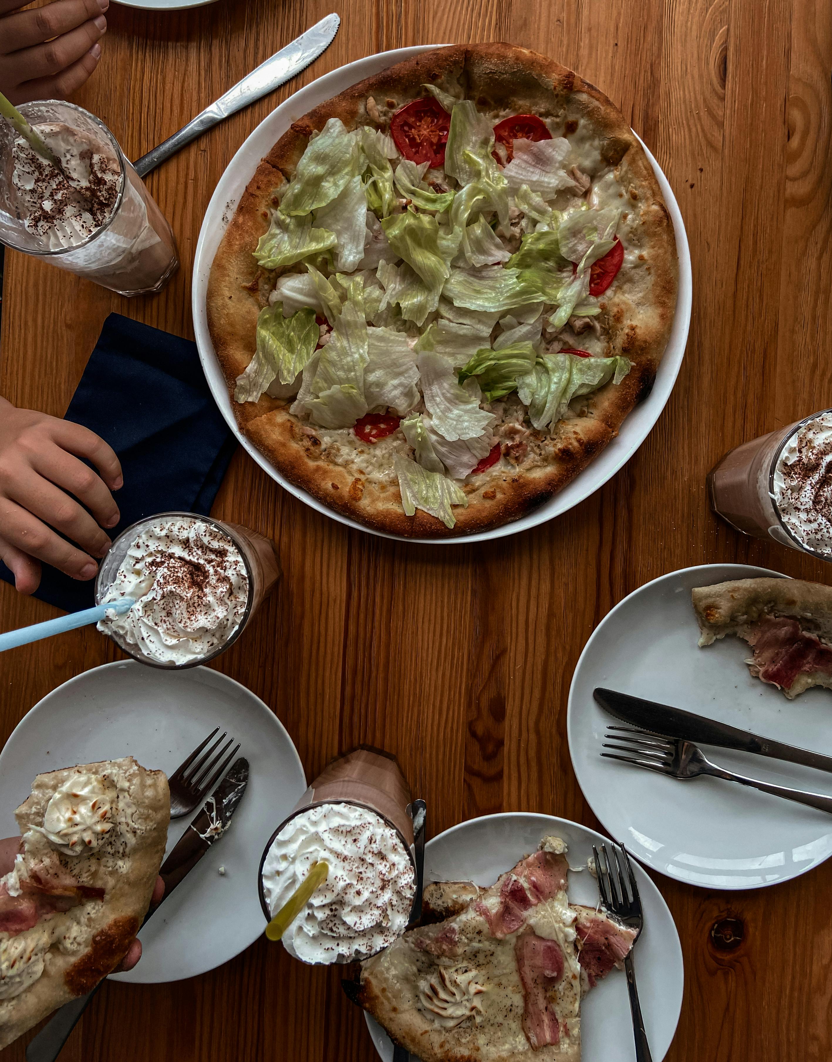 Scrumptious Pizza and Milkshakes on a Wooden Table Top · Free Stock Photo