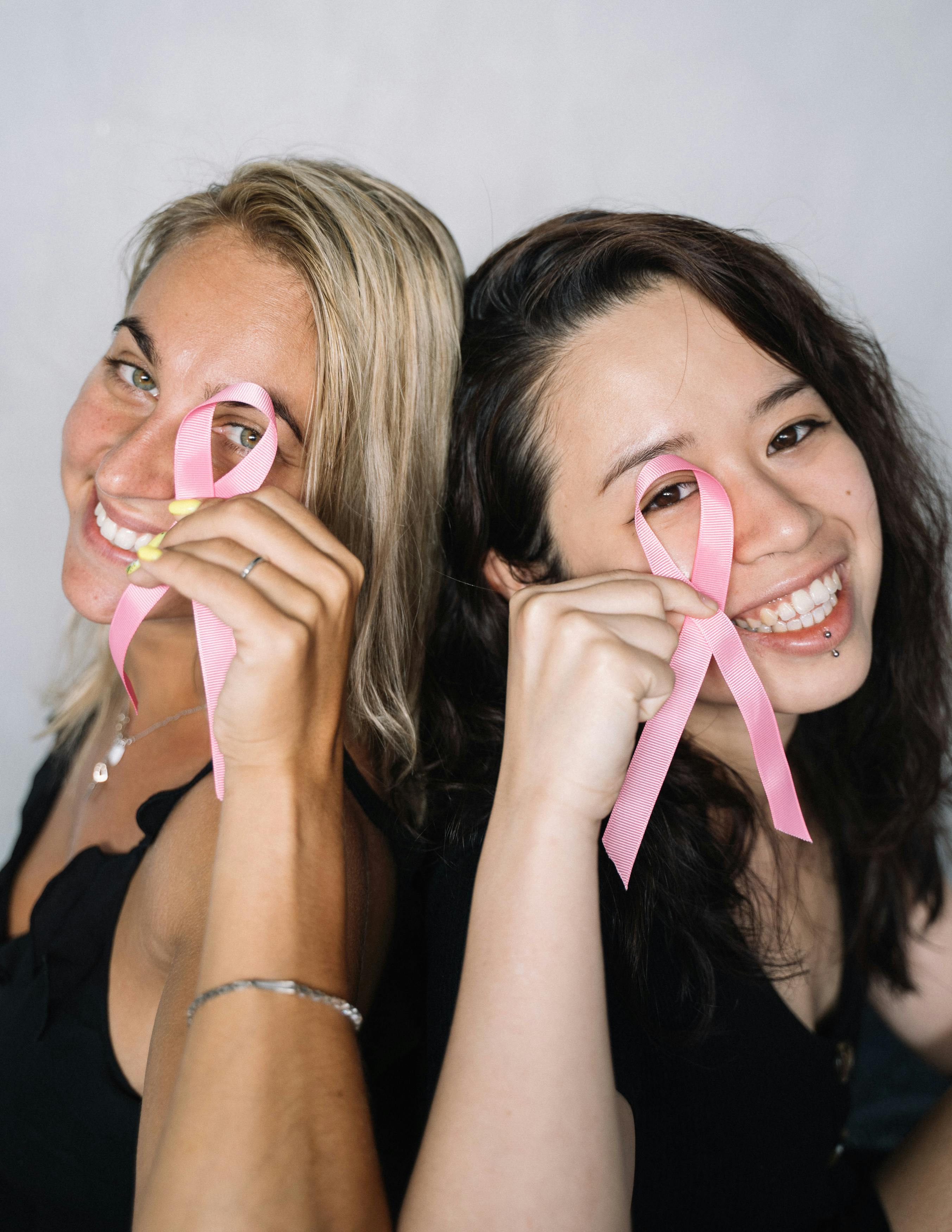 2 Women Holding Pink Ribbons · Free Stock Photo