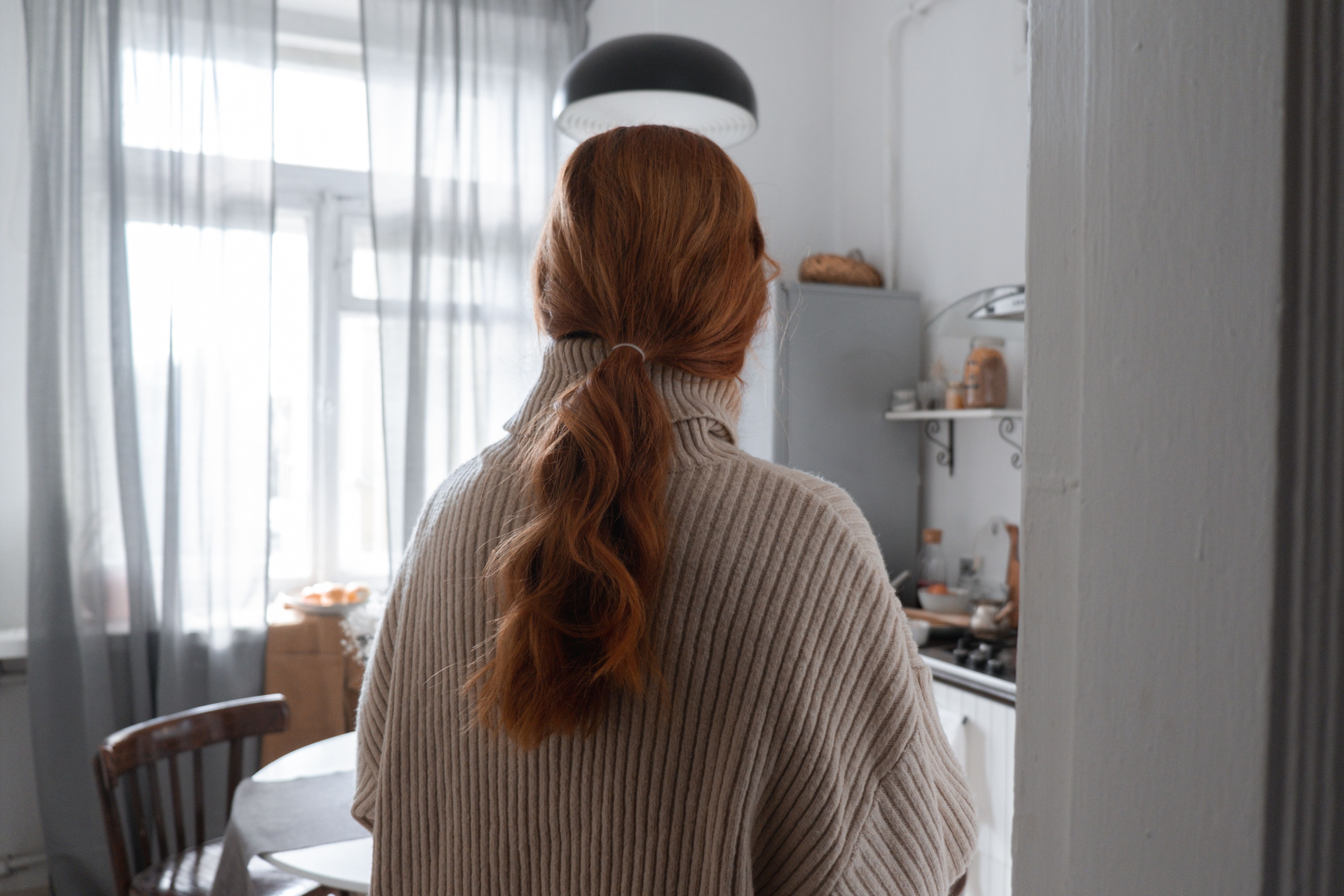 Back View of a Woman Standing in a Kitchen · Free Stock Photo