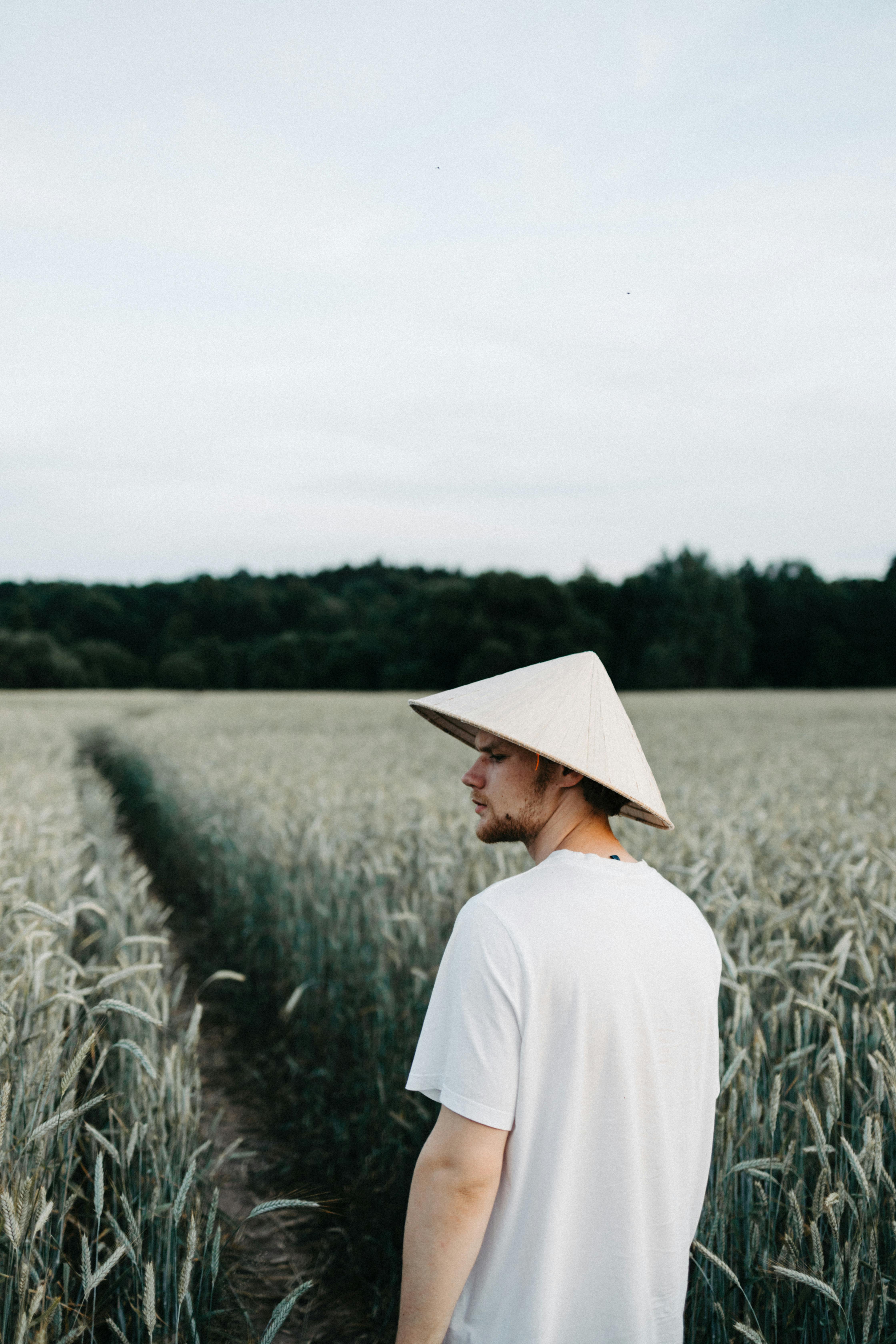 Man in White T-Shirt and Rice Hat Walking on Field · Free Stock Photo