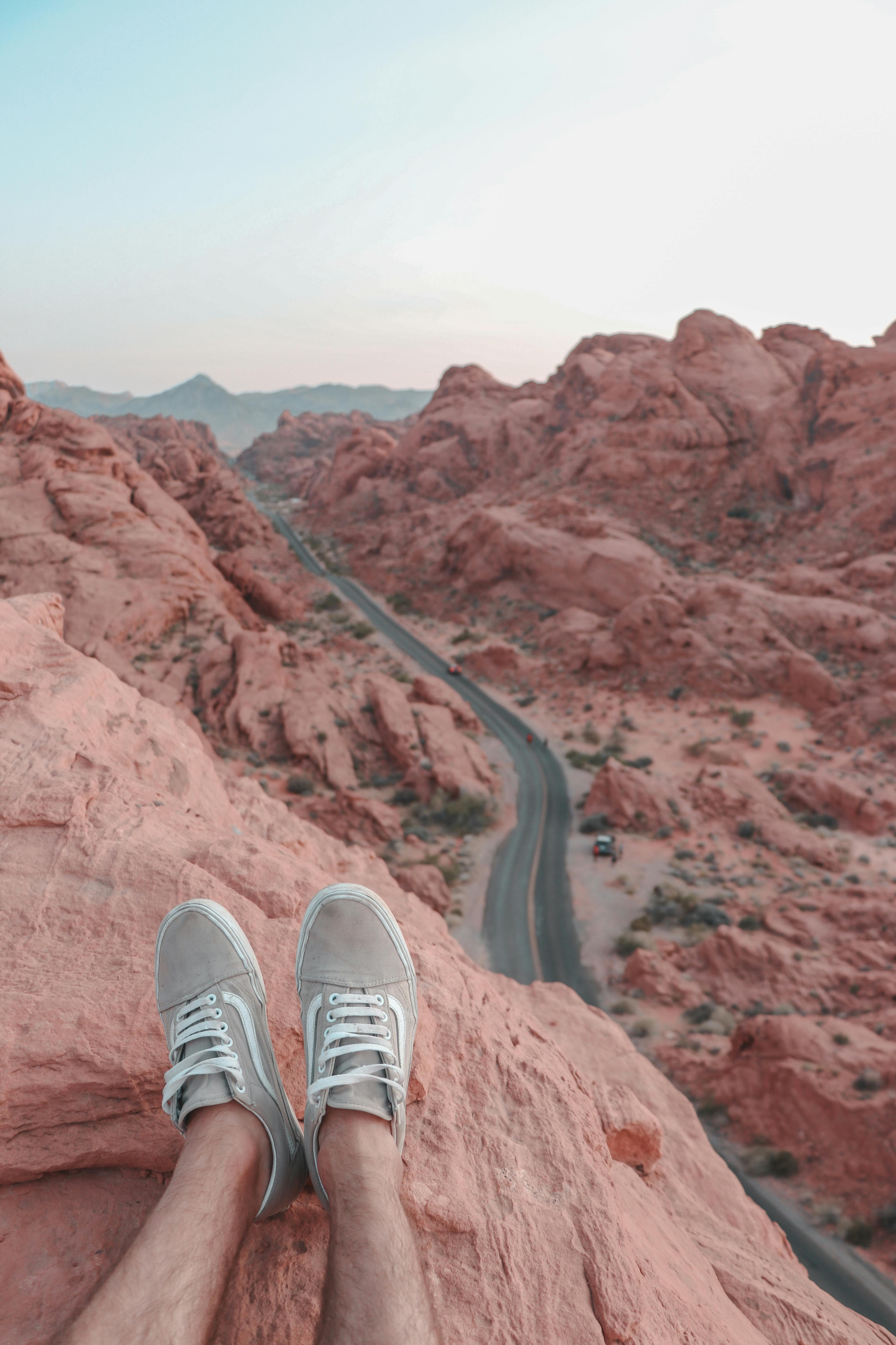 Crop man sitting on cliff · Free Stock Photo