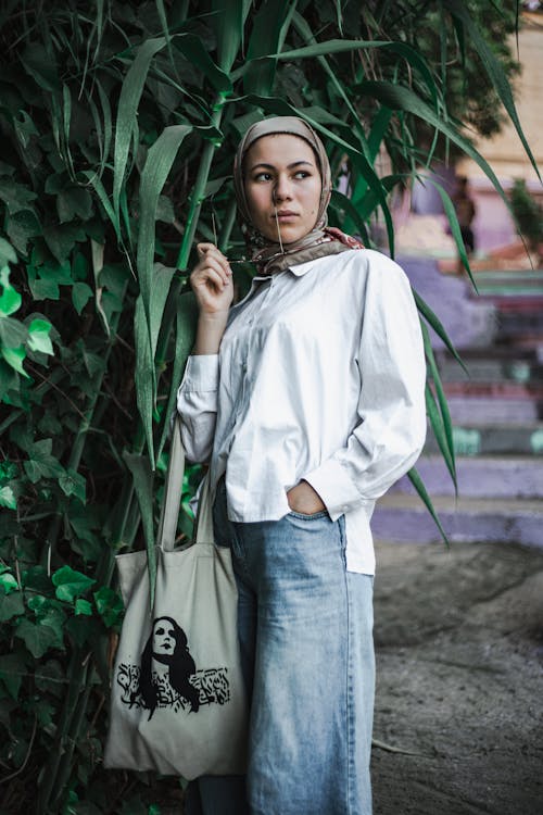 Woman In White Long Sleeve Shirt And Blue Denim Jeans Standing Beside