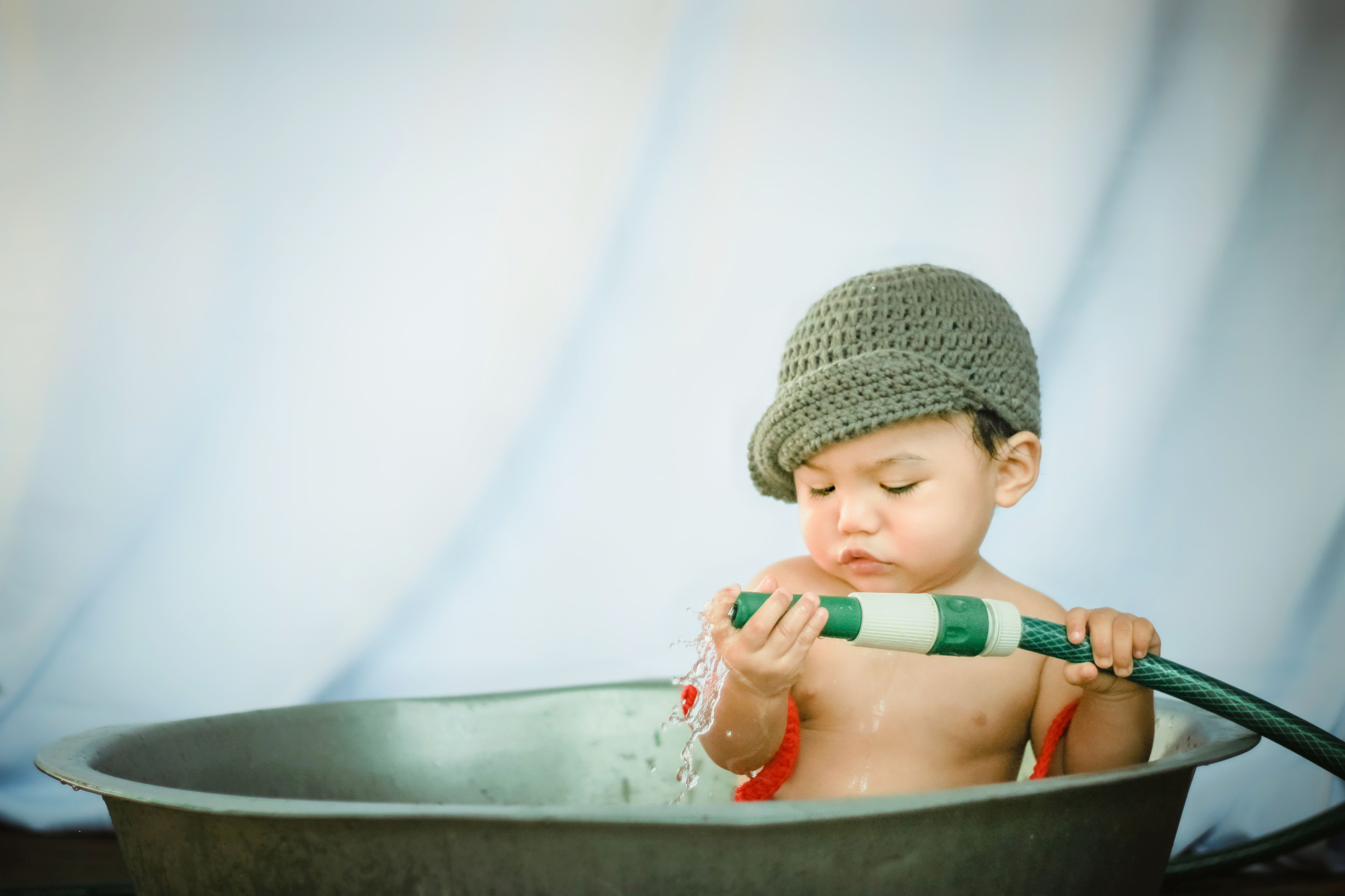 Charming little boy with hose in basin · Free Stock Photo