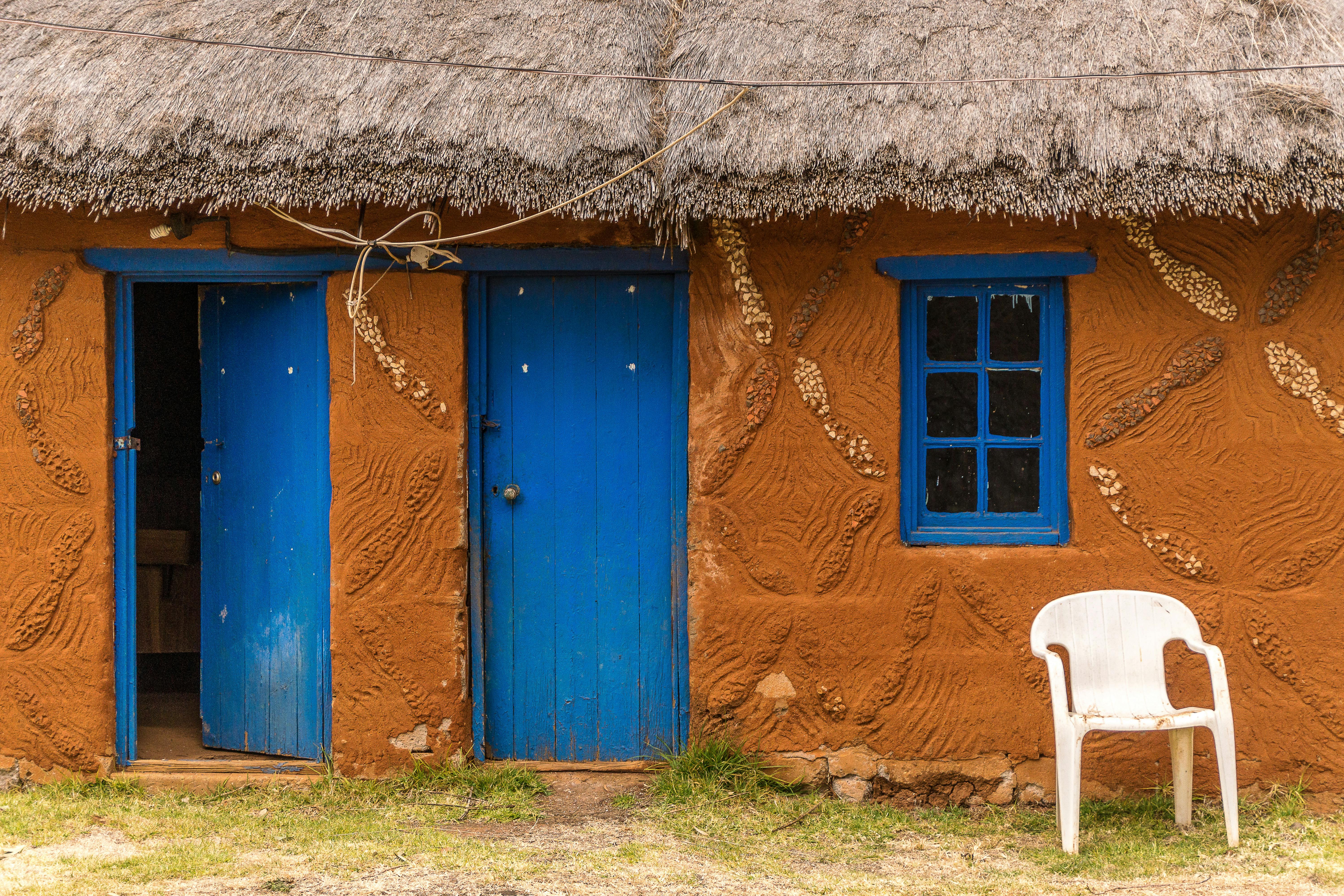 White Plastic Chair In Front Of Old Hut · Free Stock Photo